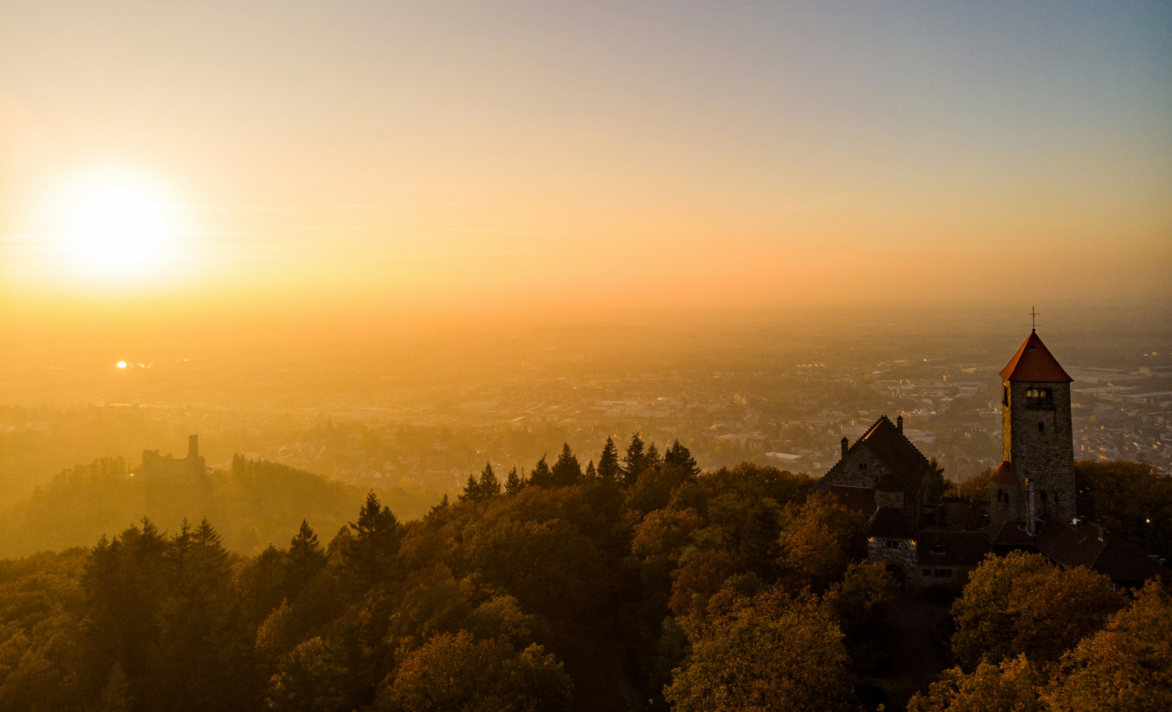 The sun is setting over a hill with a clock tower photo – Free Forest ...