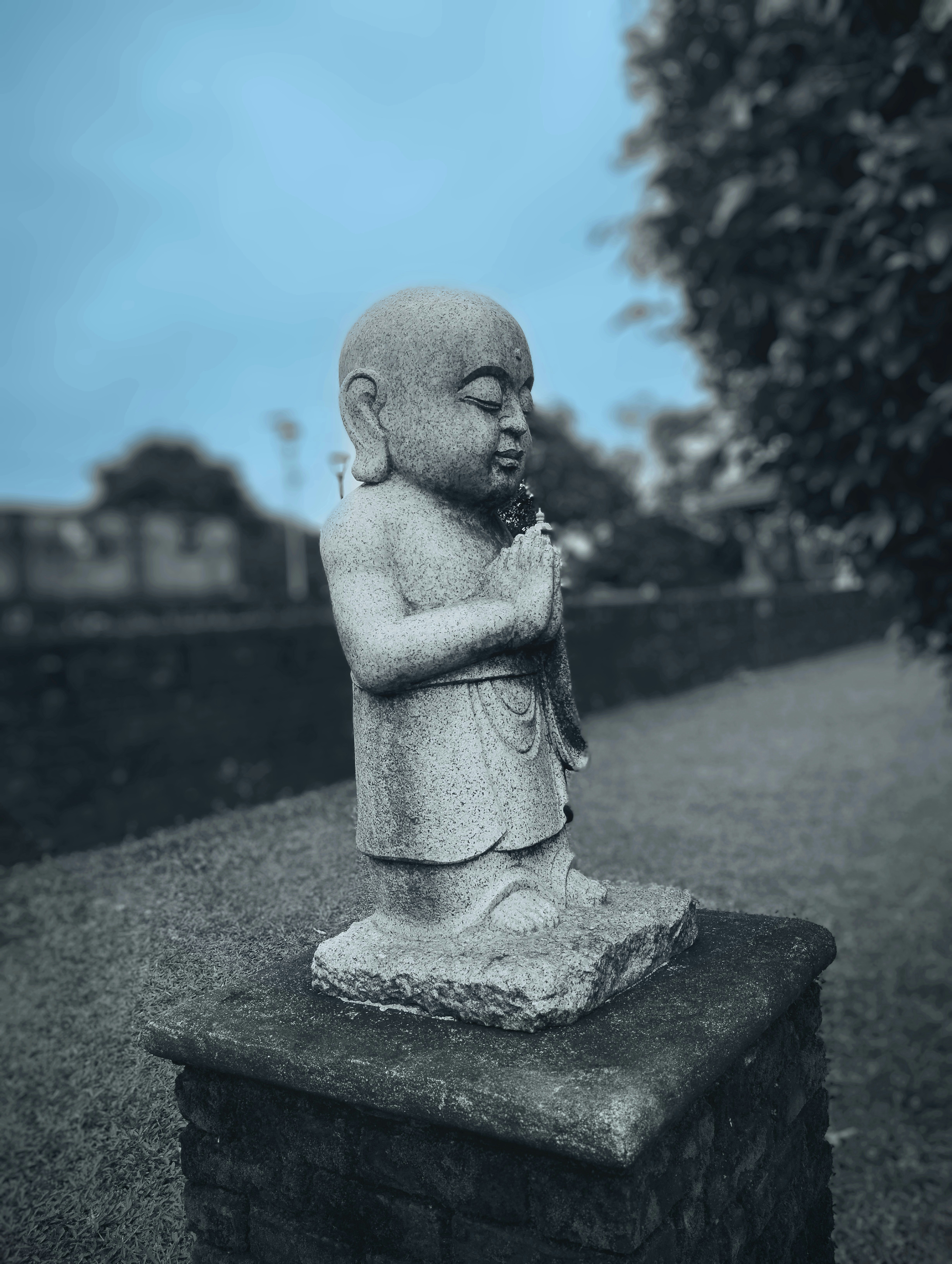 A statue of a buddha sitting on top of a stone block