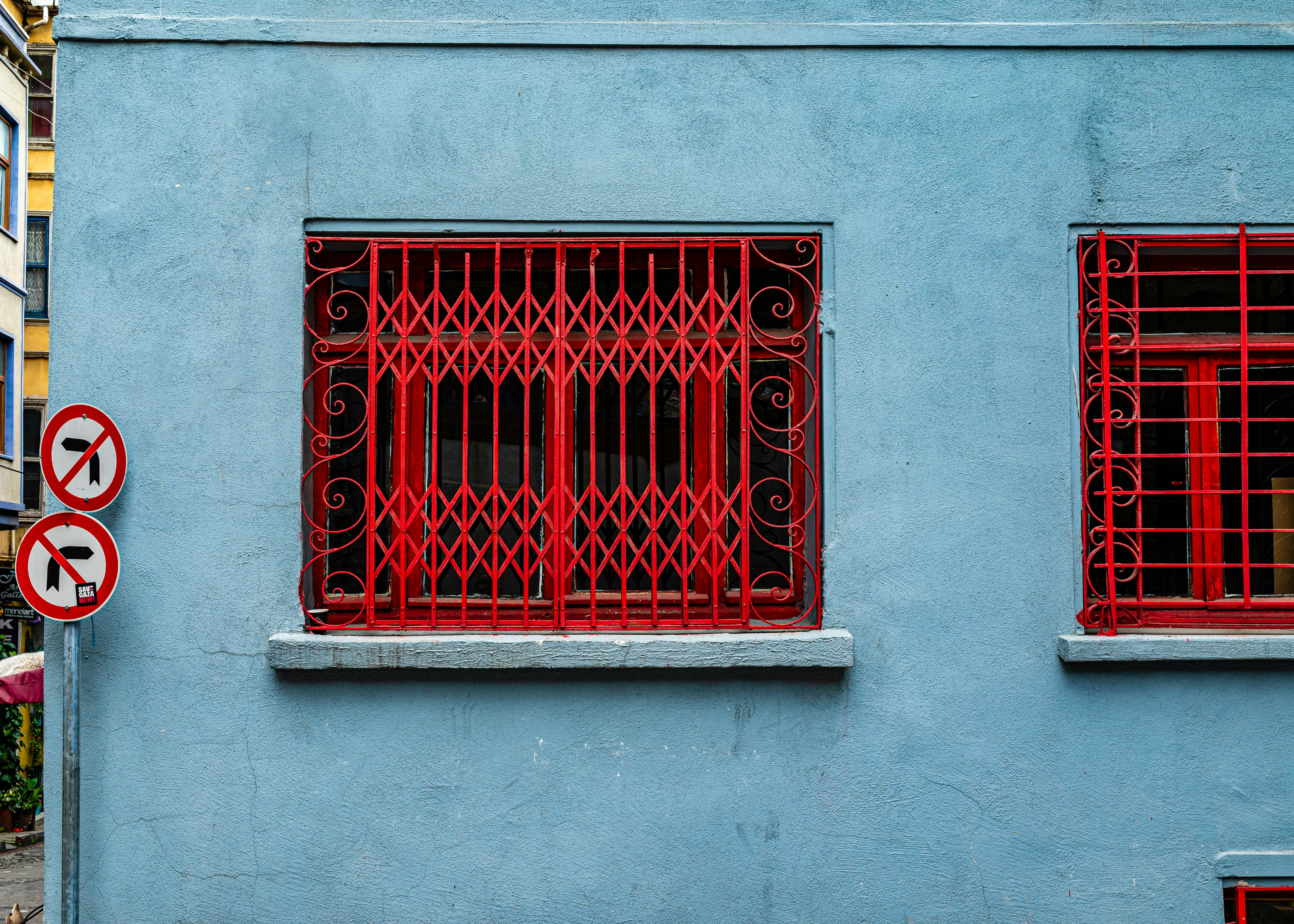 A blue building with red bars on the windows photo – Free Building ...