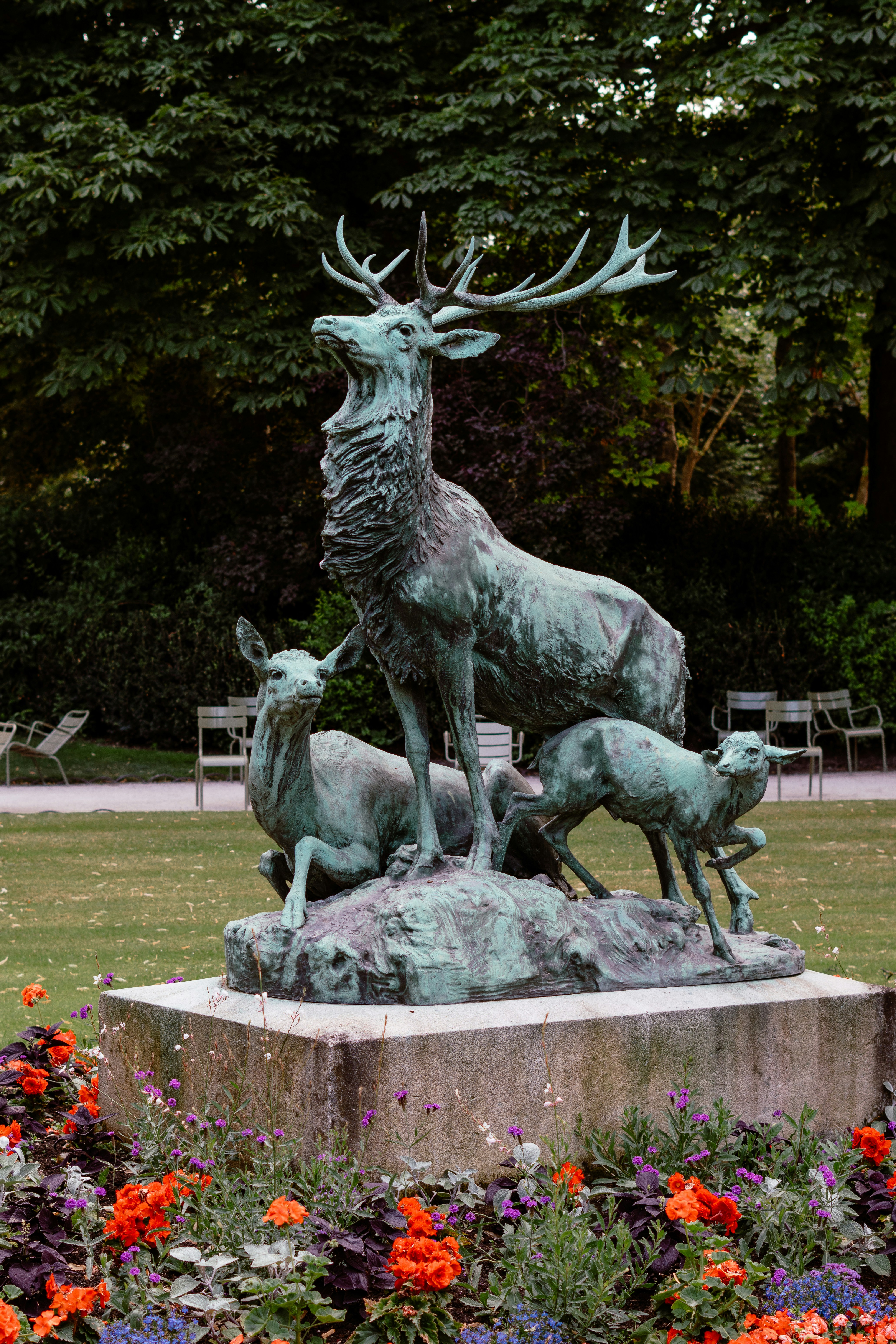 Bronzed Stag with Attendant Fawns: a garden sculpture at dusk