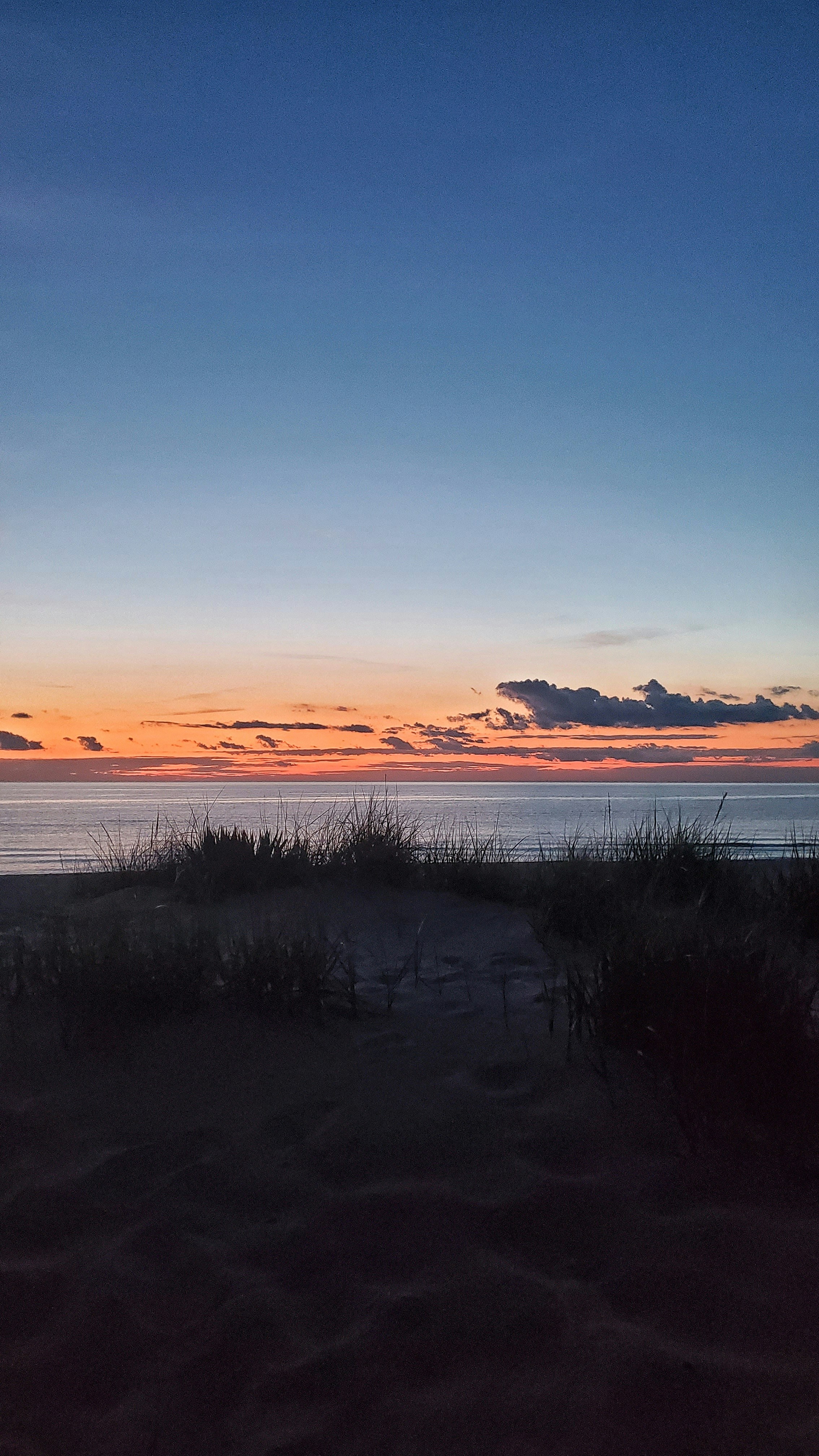 The sun is setting over the ocean on the beach photo – Free Beach Image on Unsplash