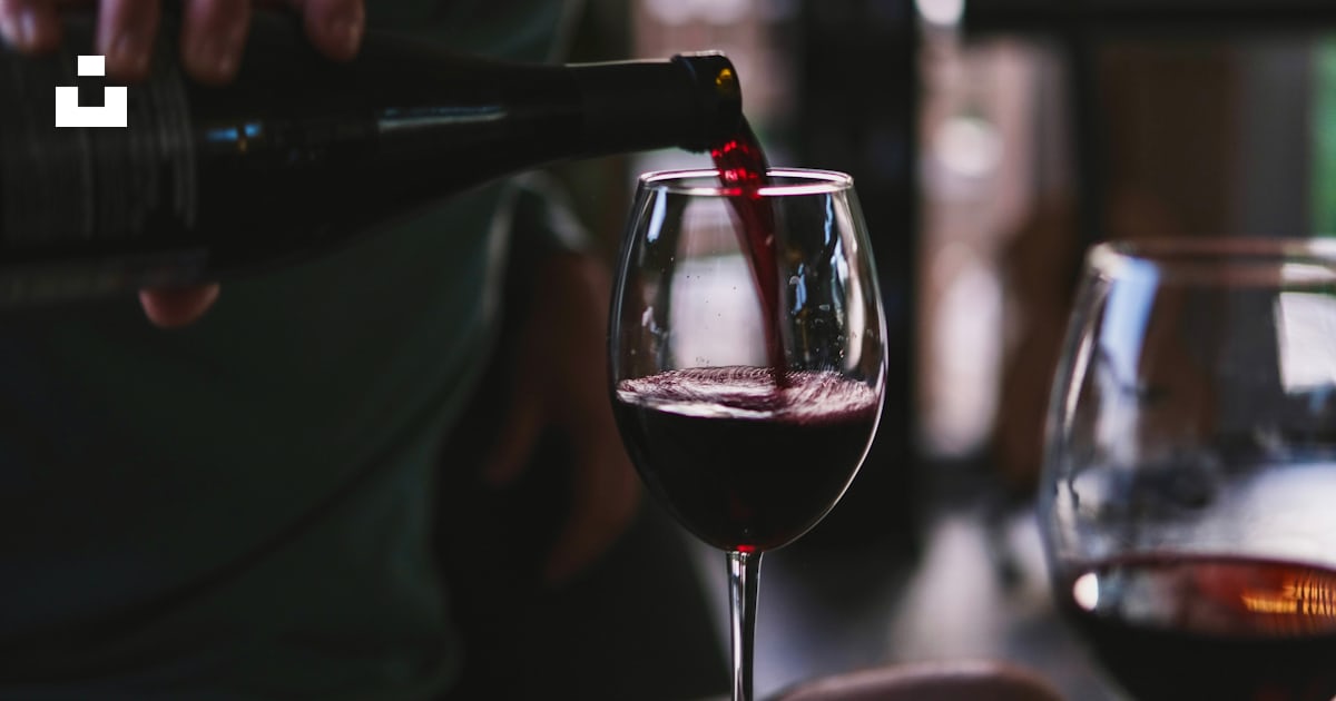 A Person Pouring Red Wine Into A Glass Photo Free Grey Image On Unsplash