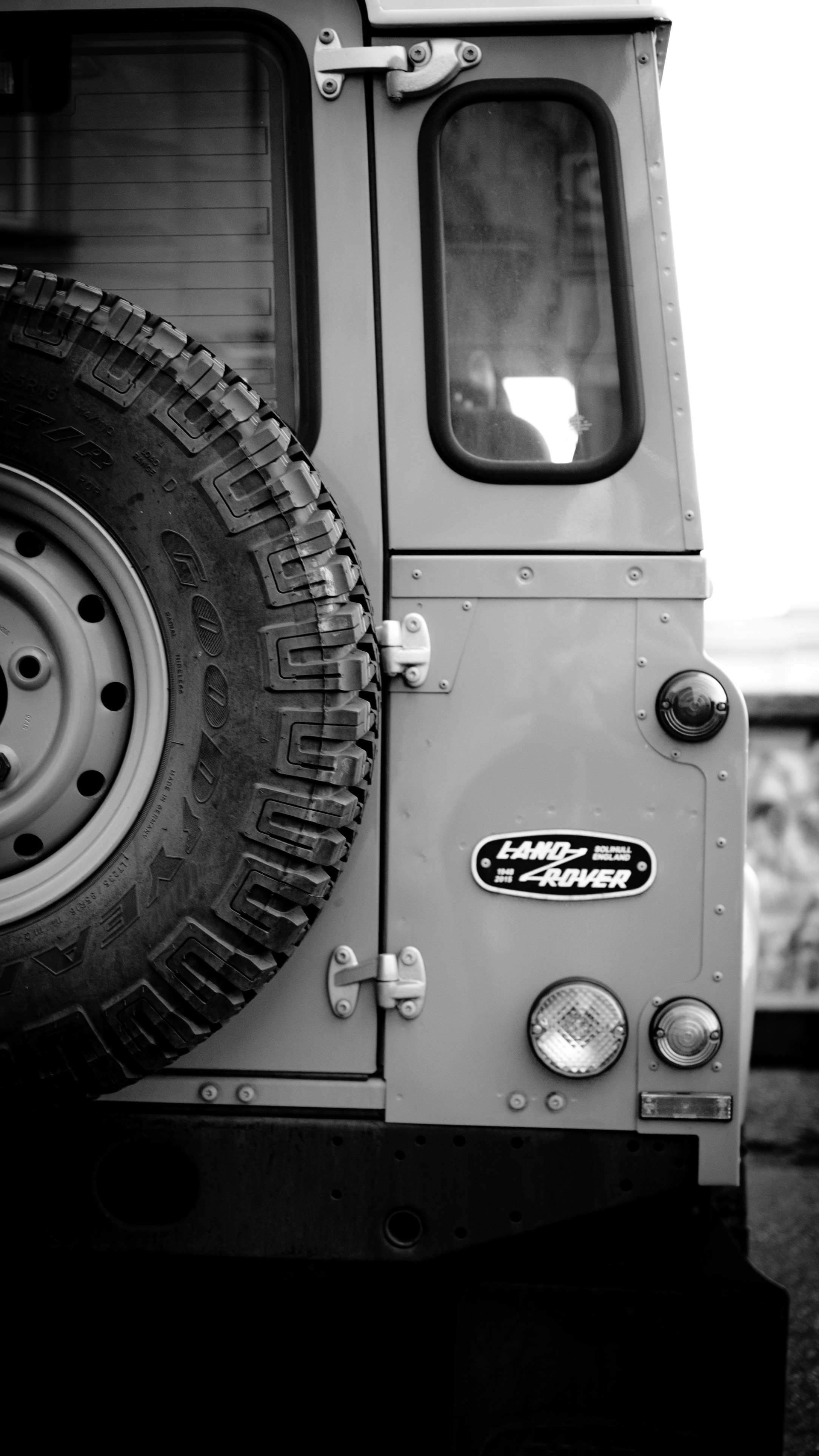 Rear Portrait of a Land Rover Defender: Spare Tire, Rivets, and Badge
