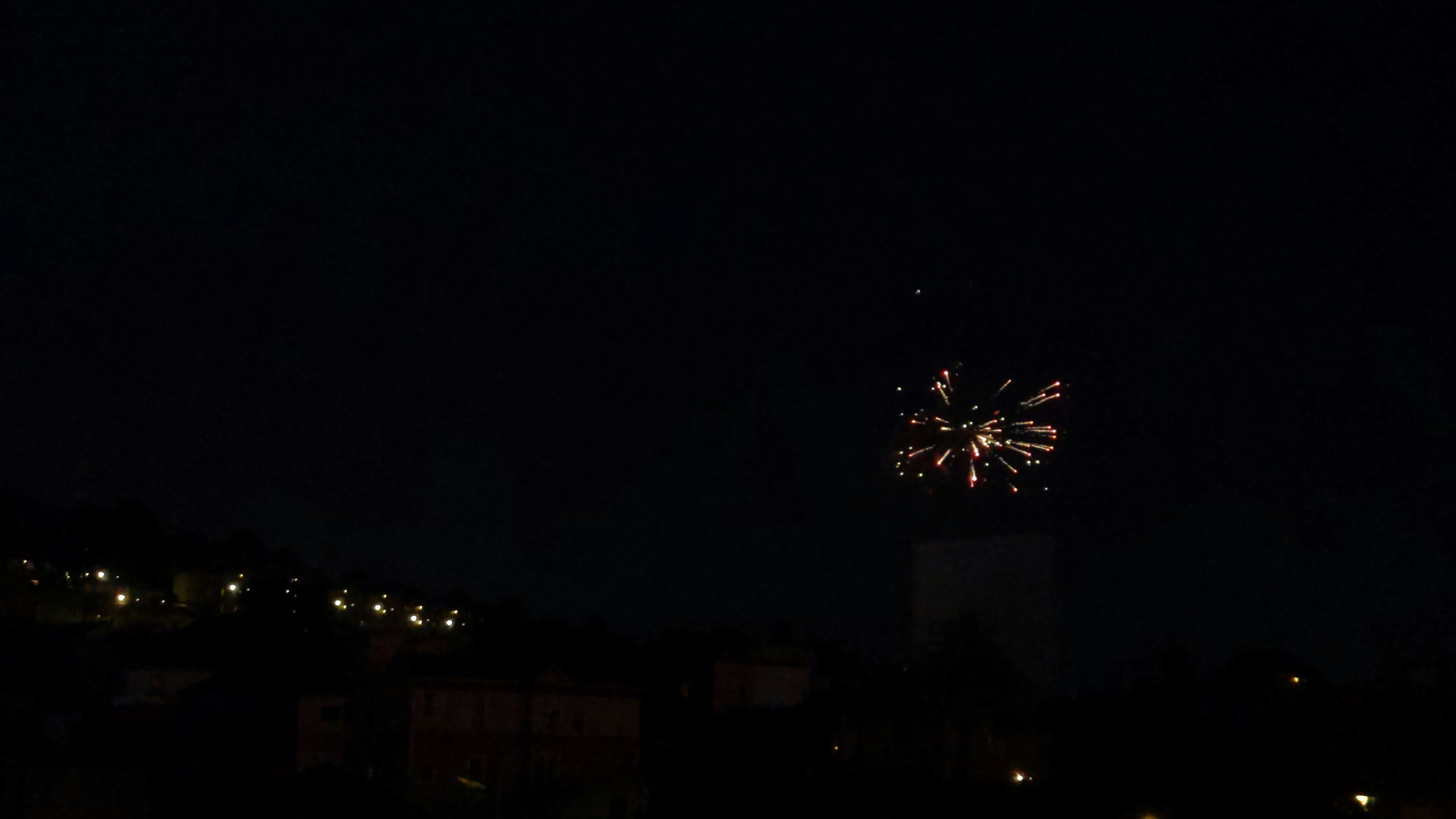 Firework Bloom over a Quiet Town Silhouette