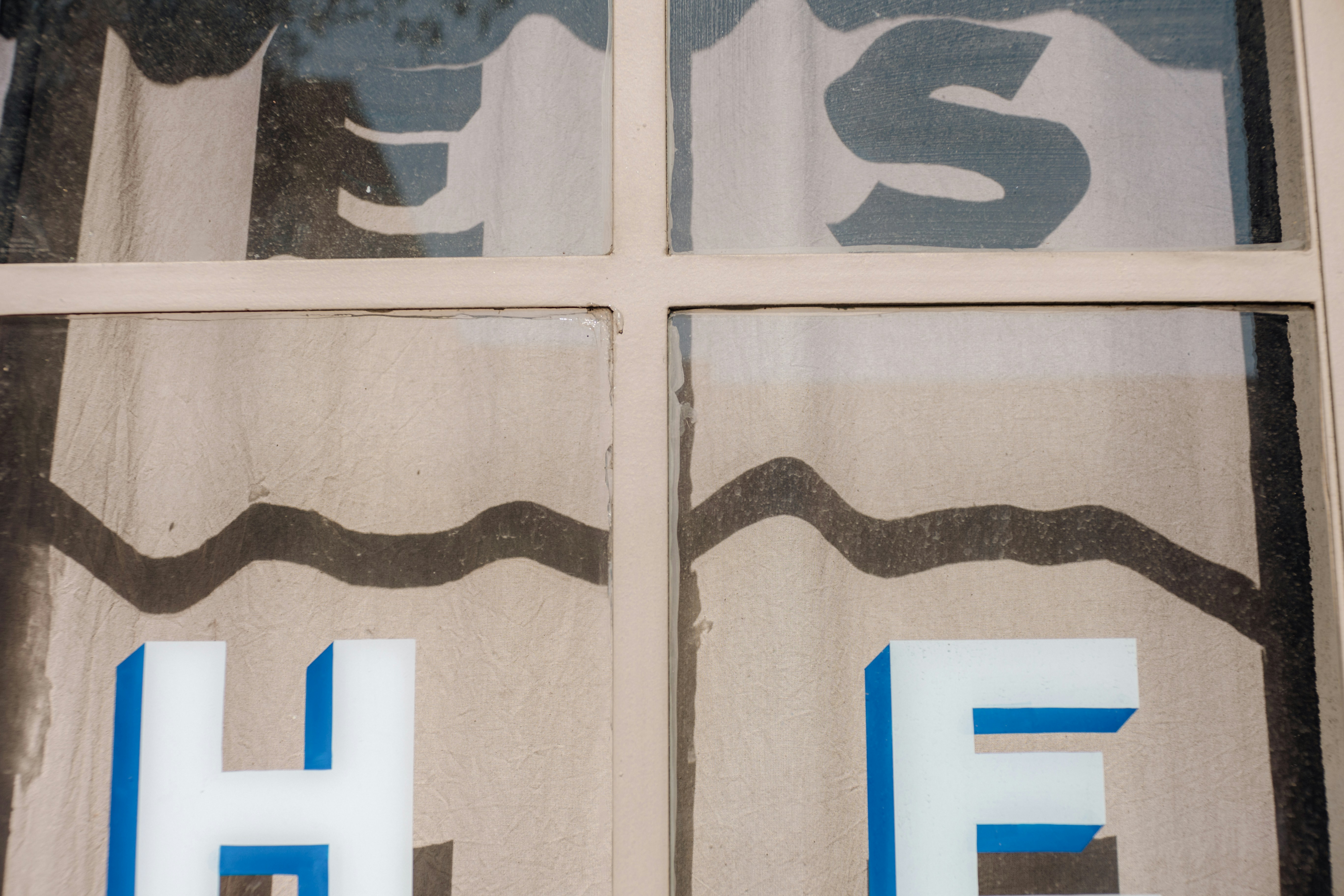 Letters in a Window: Fragmented Signage Beneath Stained Glass