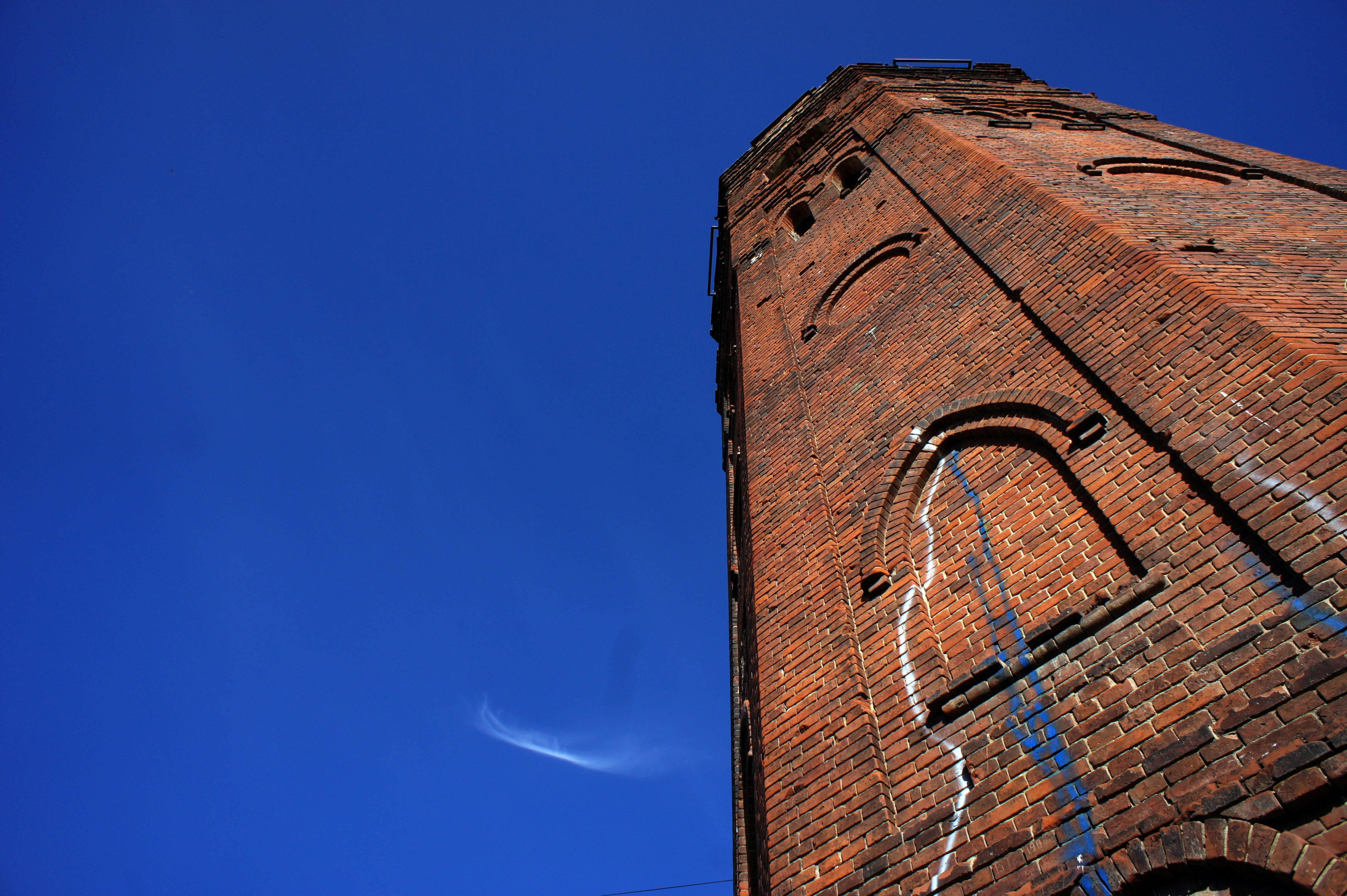 Brick Sentinel Under a Cerulean Sky, Graffiti Traces