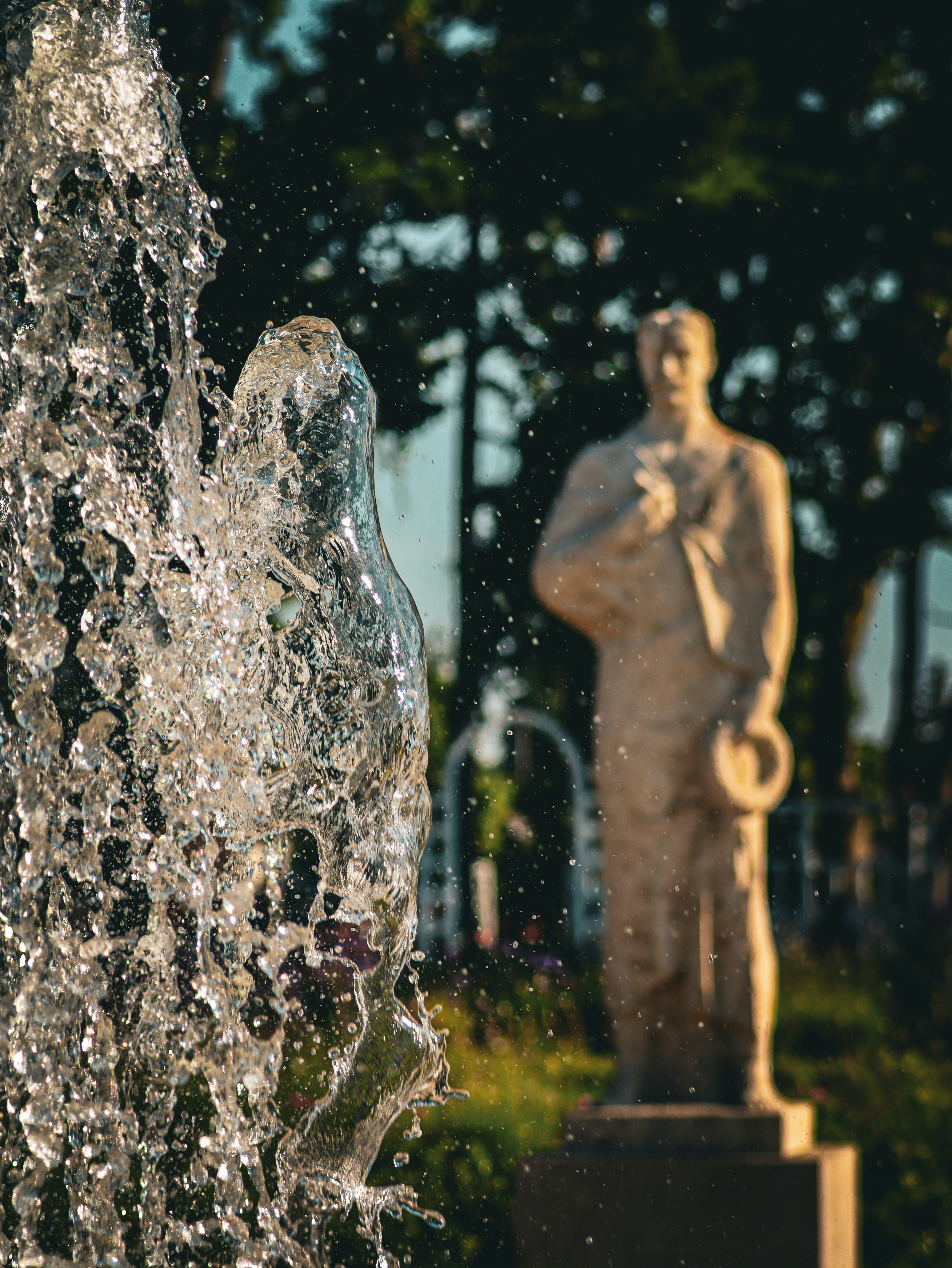 Liquid Light: A Fountain's Spray Framed by a Distant Statue