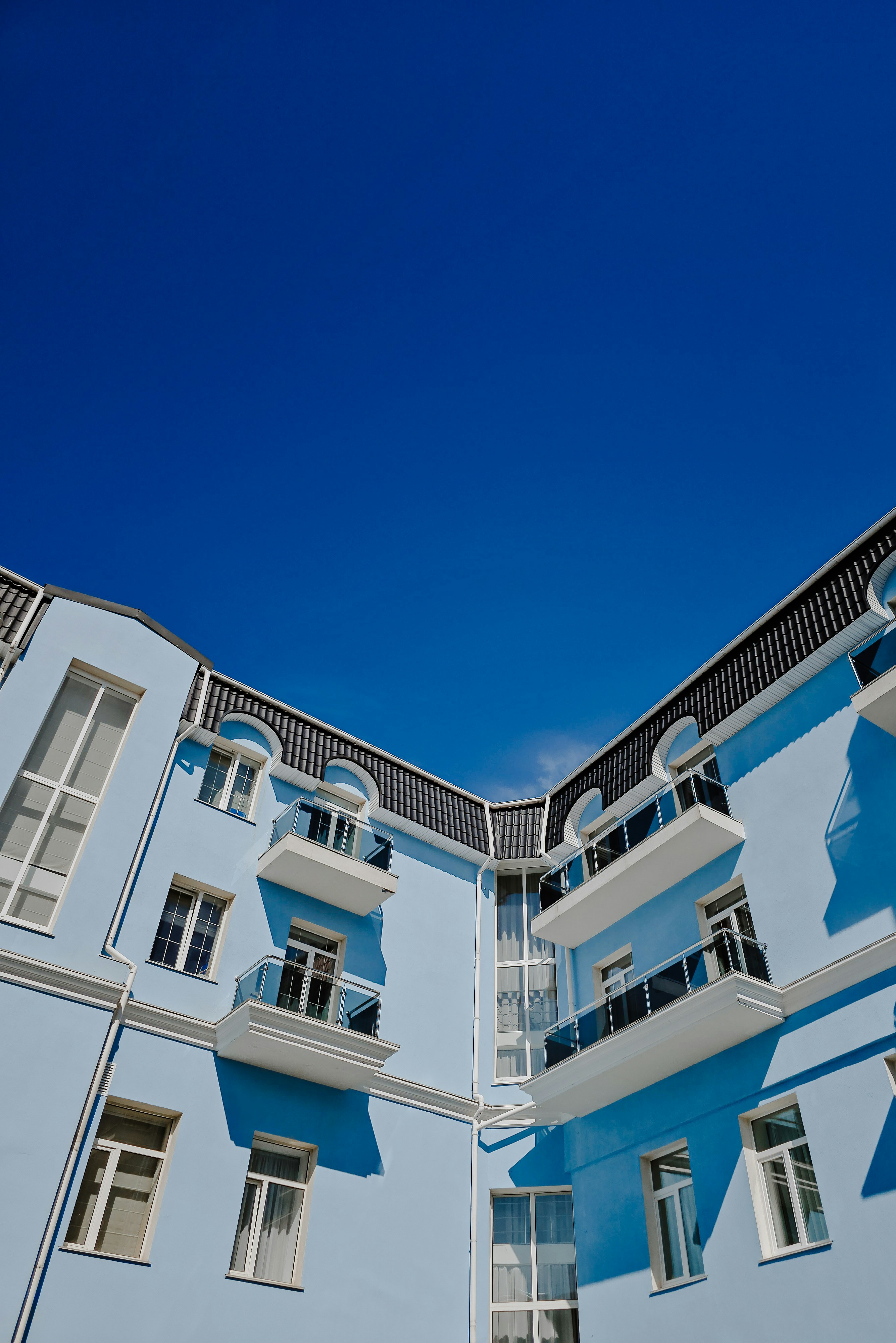 A blue and white building with windows and balconies photo – Free ...
