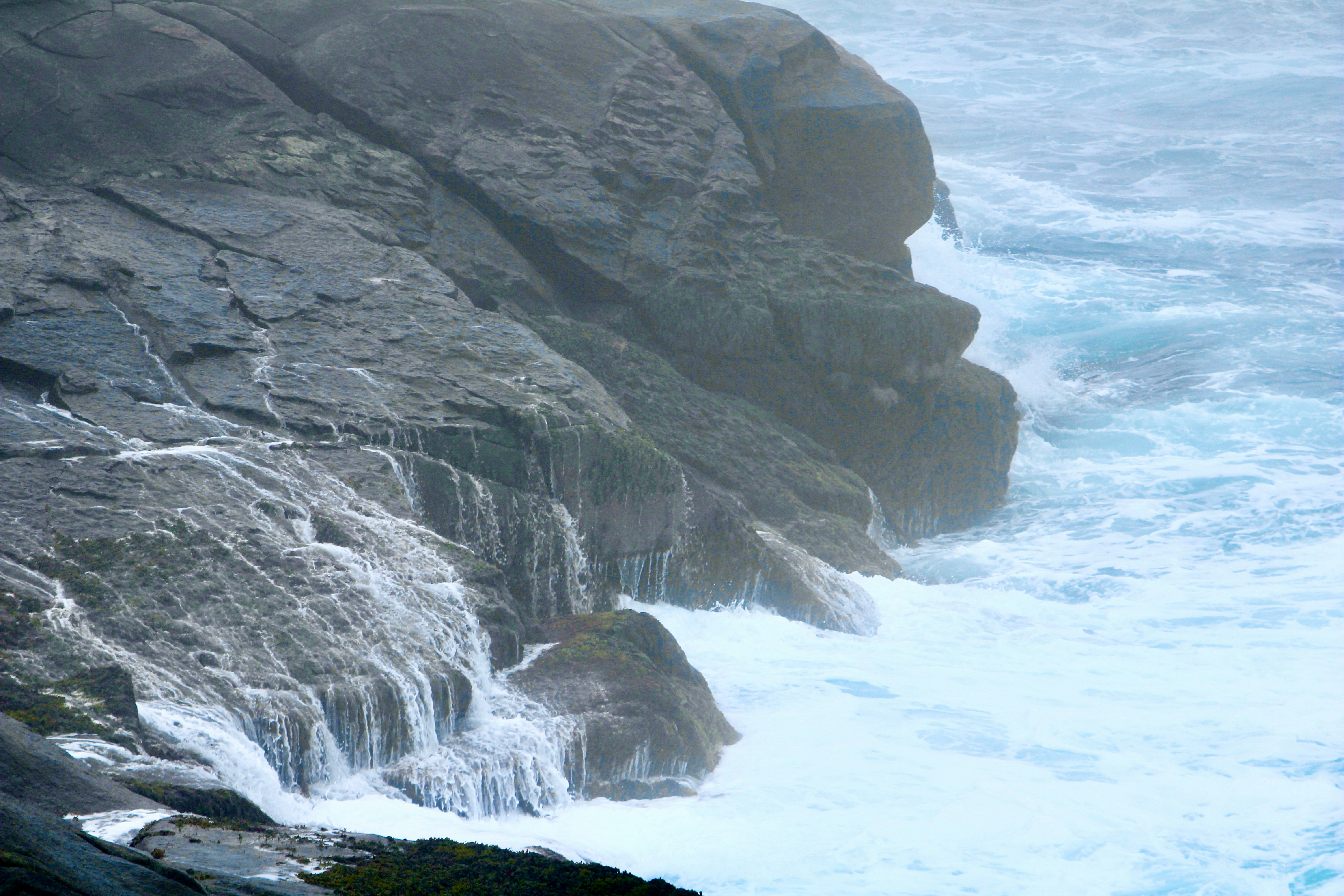 Edge of the Break: Weathered Cliffs and the White Foam of a Churned Sea