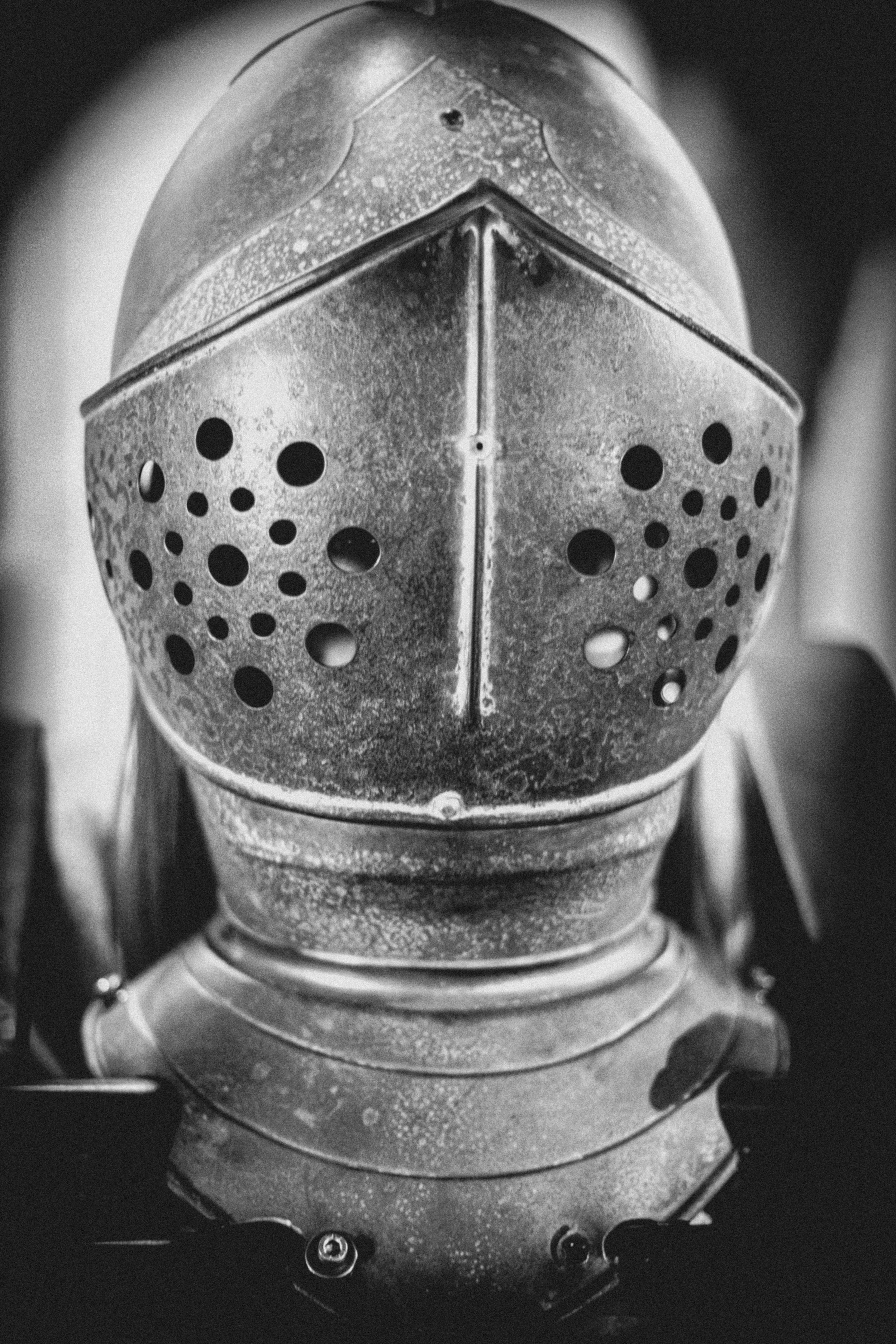 Close-up of a medieval knight's helmet, showcasing intricate details and a weathered surface. The image captures the essence of historical craftsmanship.