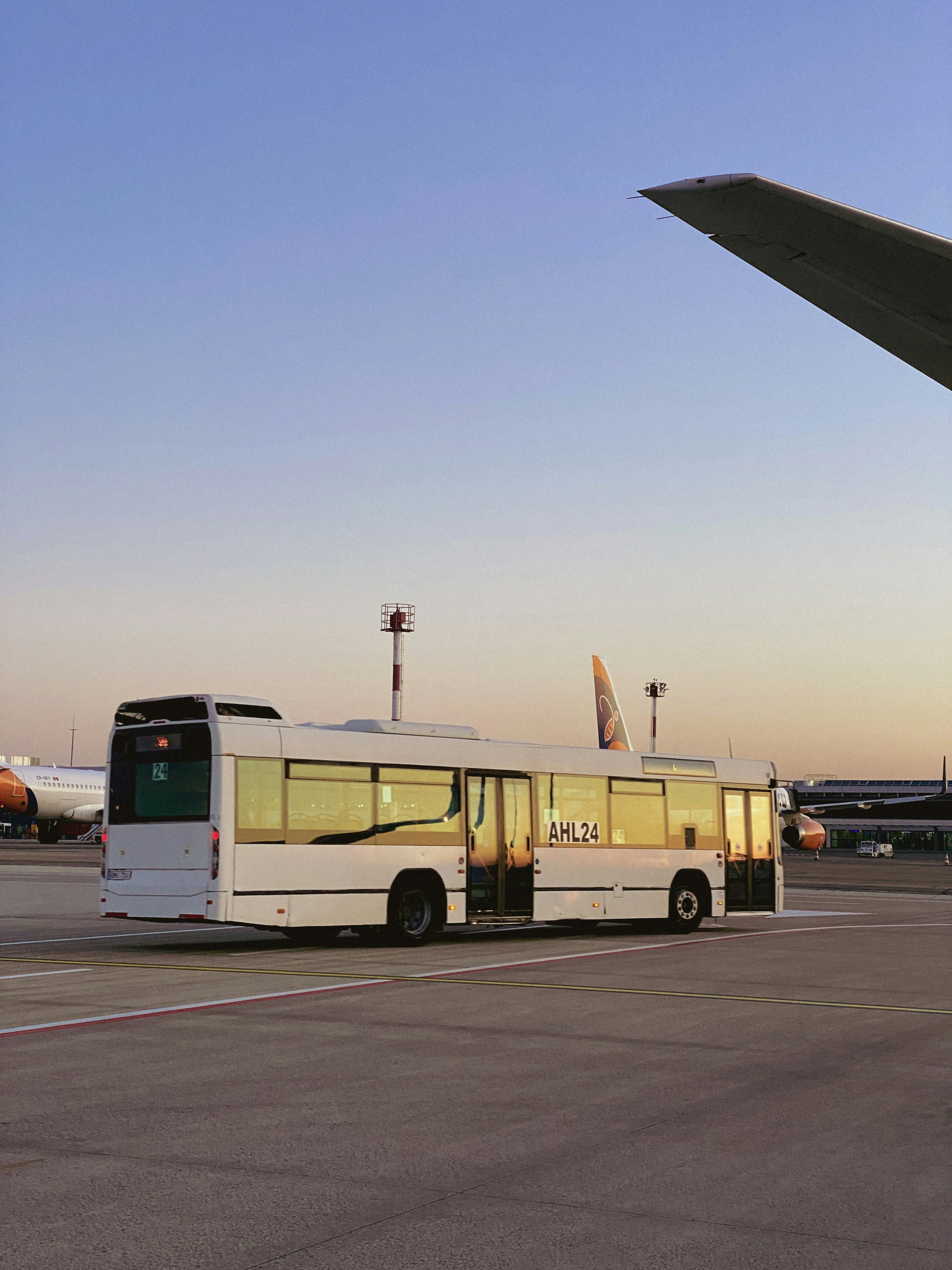 Dusk at the Gate: White Airport Shuttle Quietly Rests on the Runway