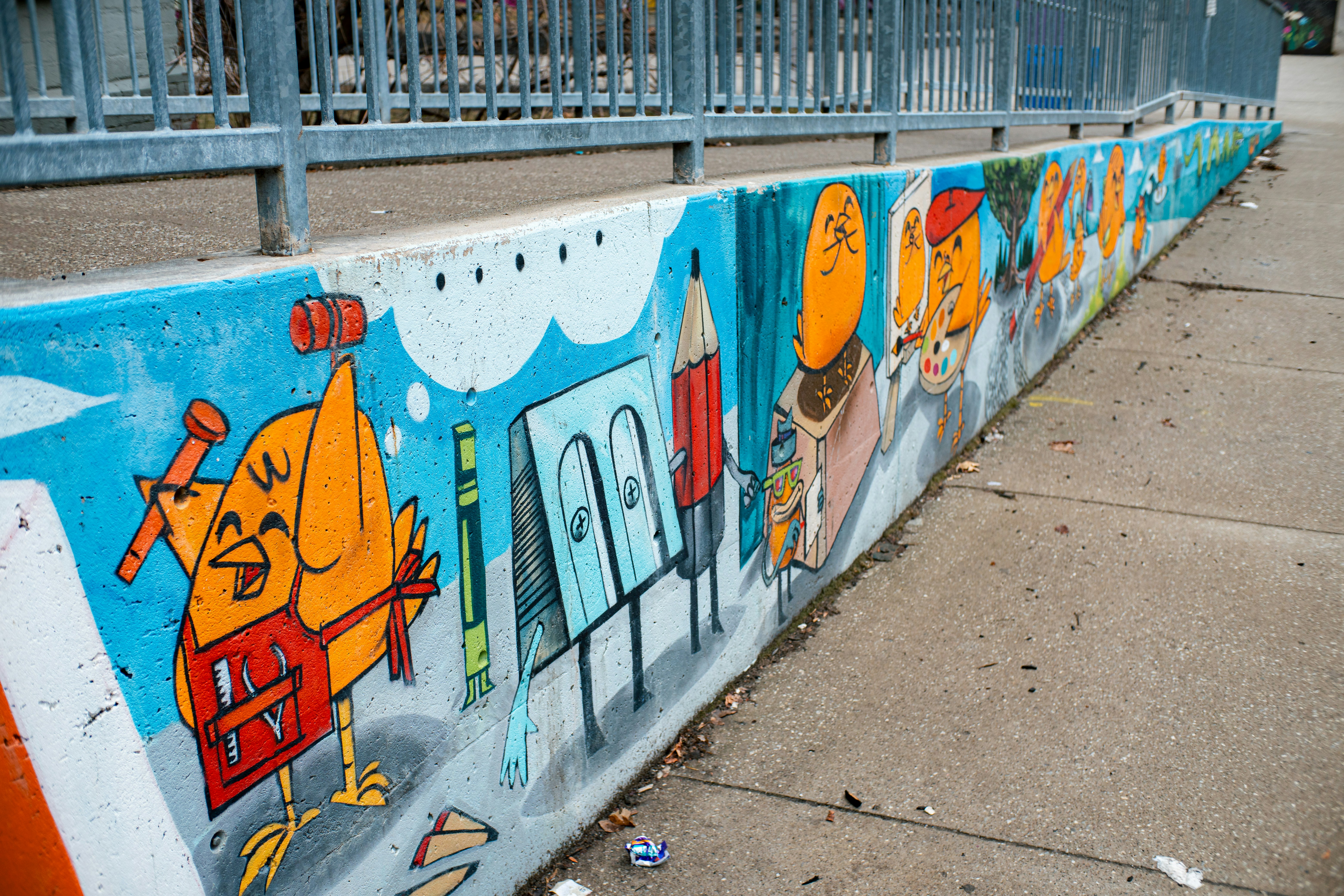 Vibrant mural featuring cartoon birds engaged in various activities, showcasing creativity and playfulness. The artwork brightens the urban landscape.
