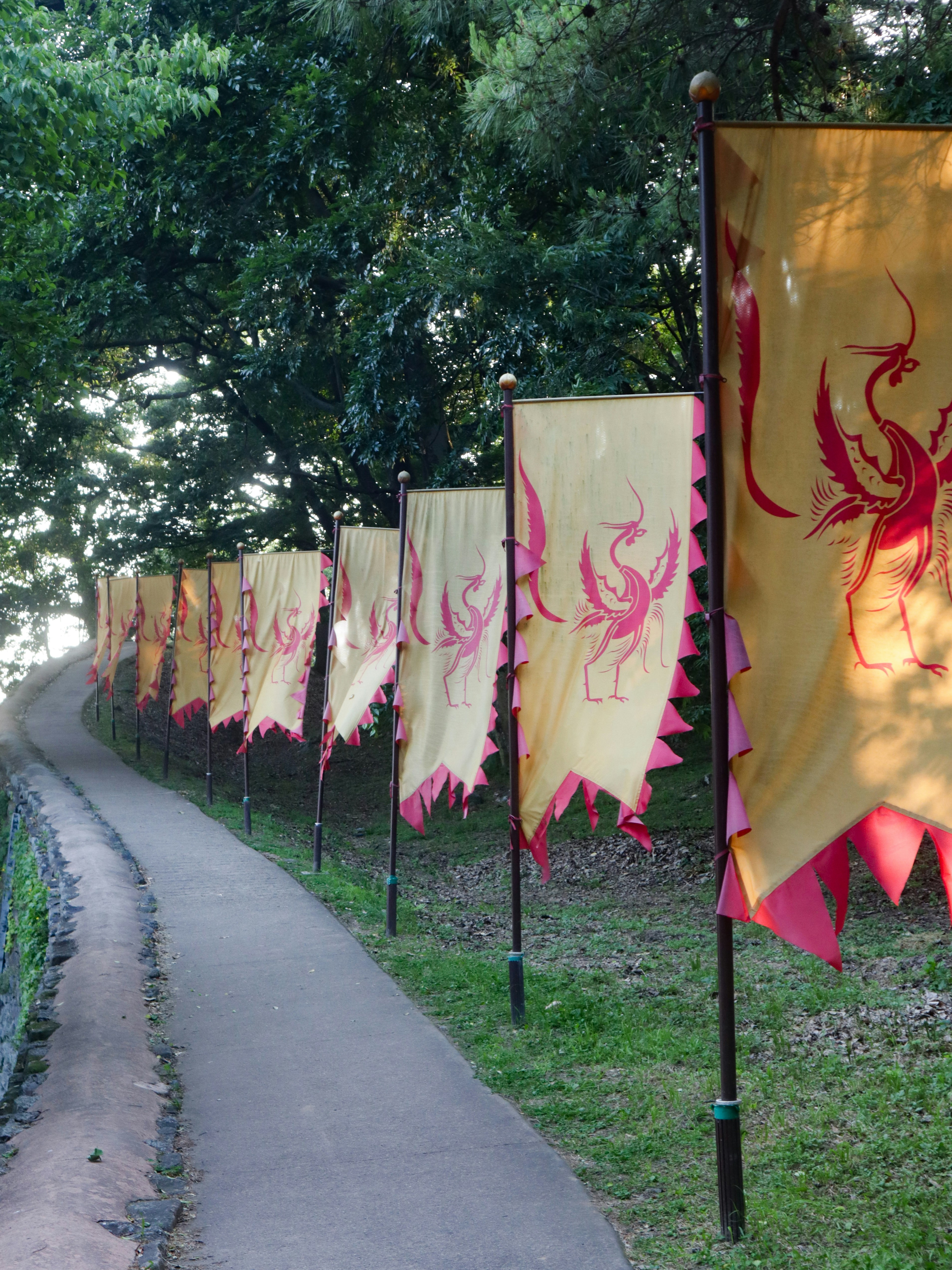 Amber Dragon Flags Line a Winding Park Path