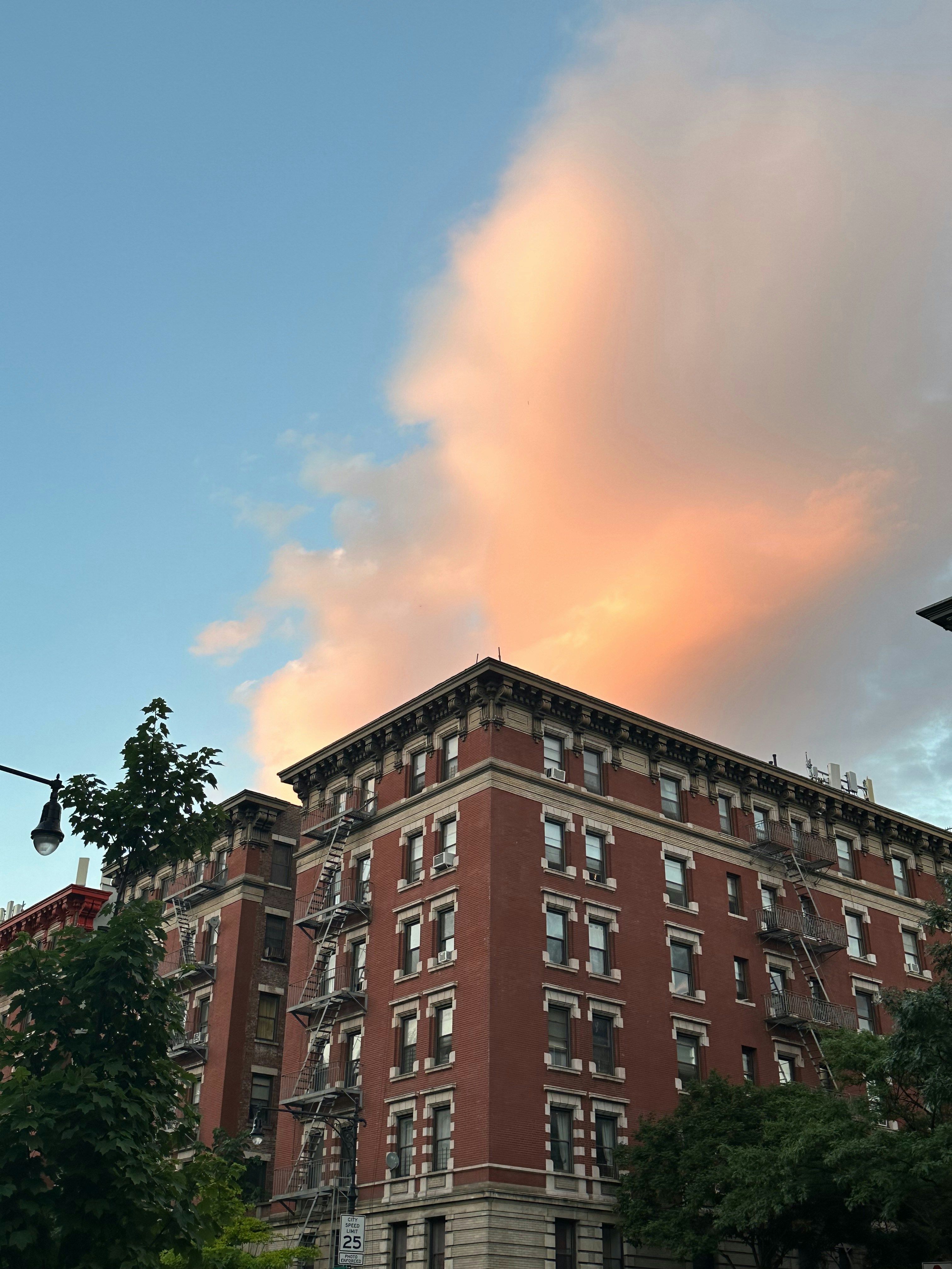 Sunlit Cloud Above a Classic Brick Apartment Block