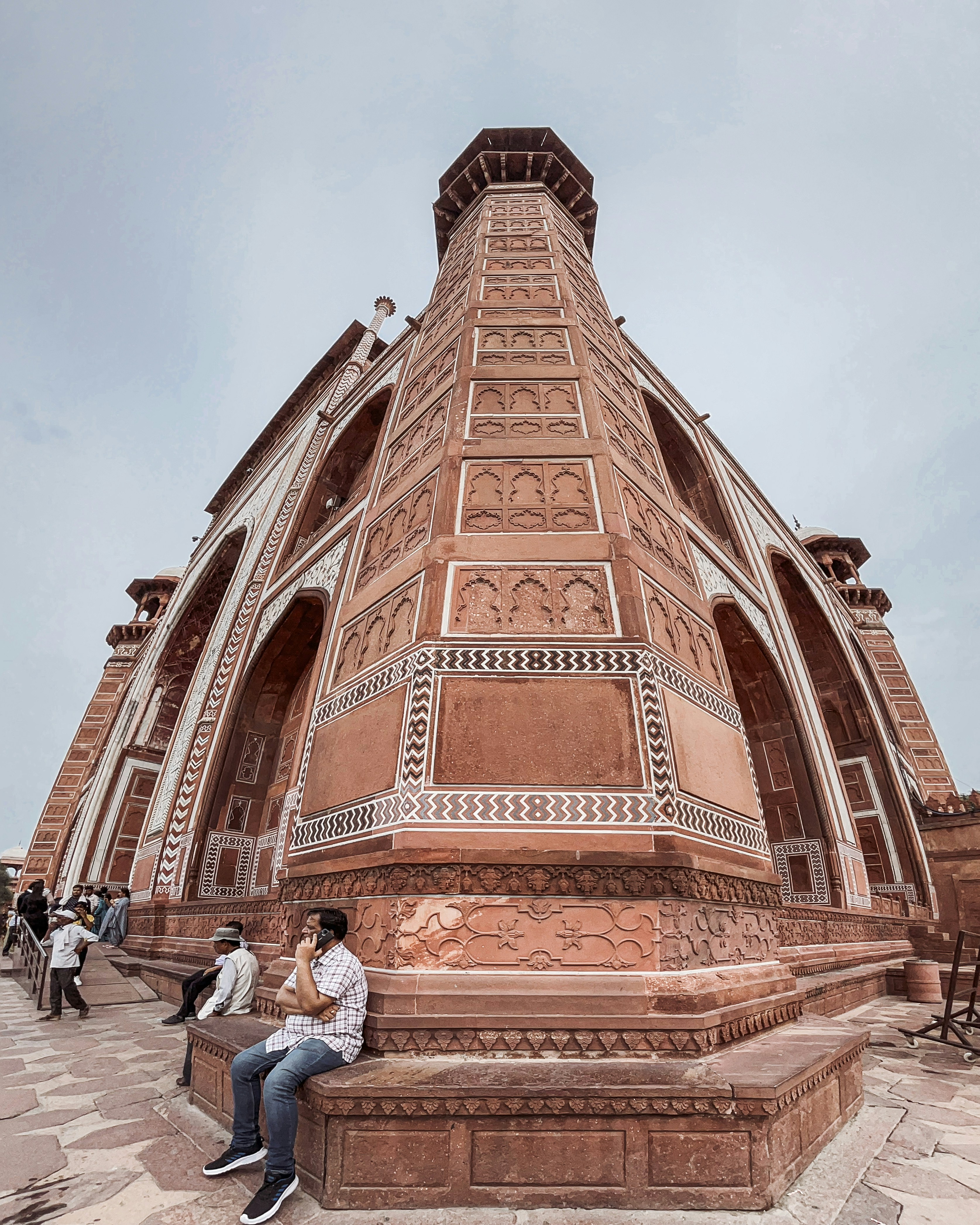 Two people sitting on a bench in front of a building photo – Free Taj ...