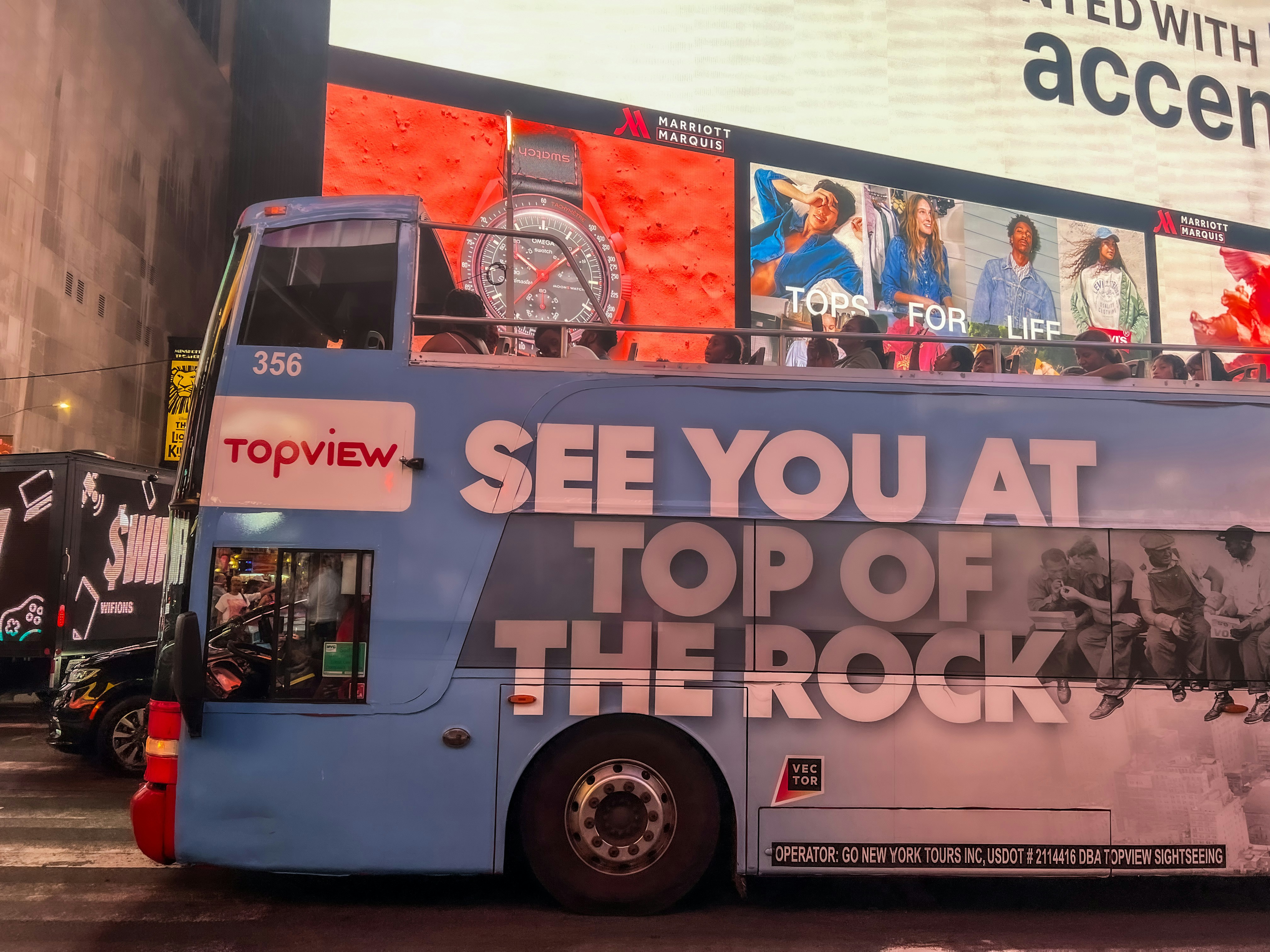 A blue double decker bus driving down a street photo – Free Times ...