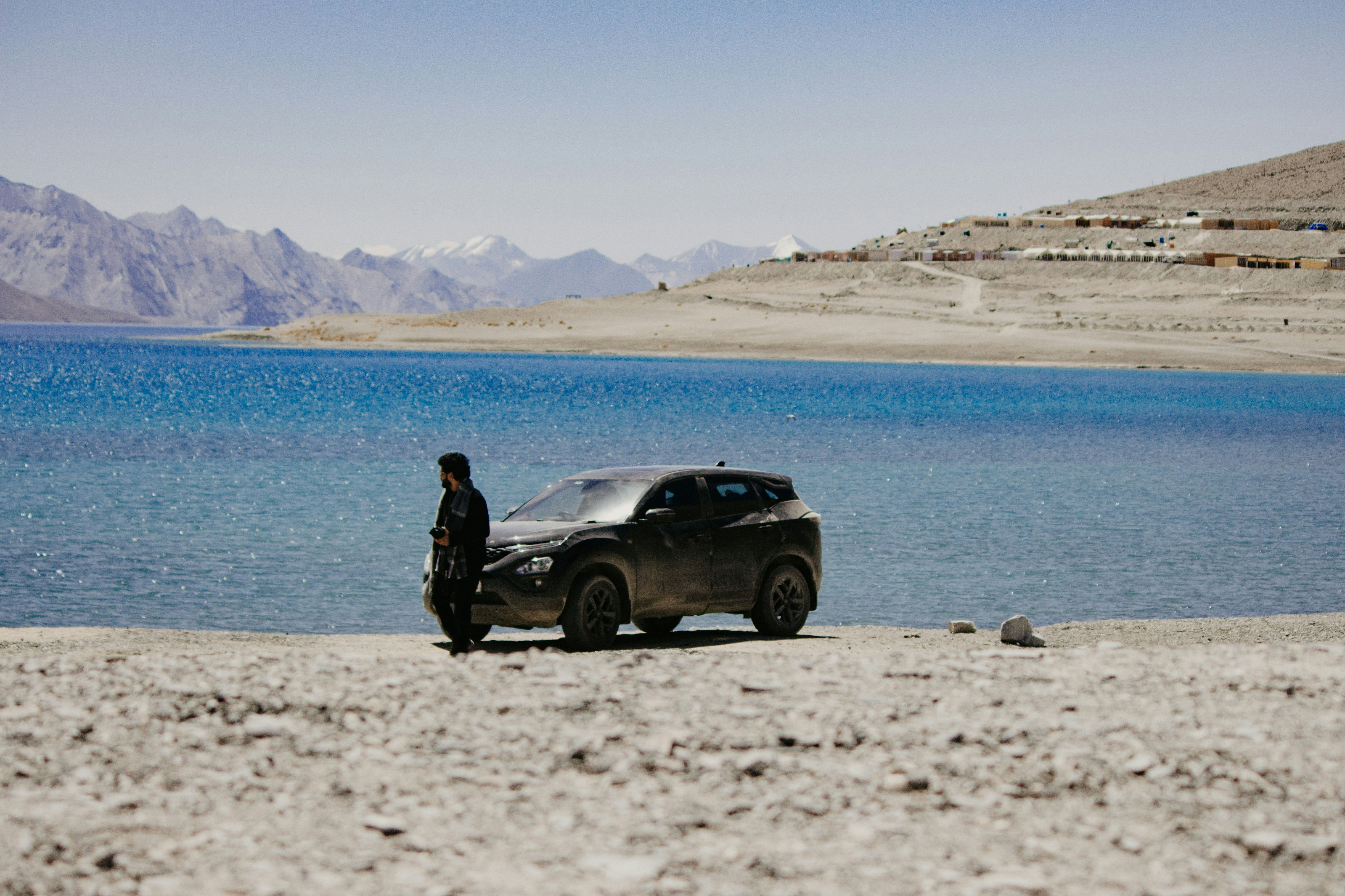 Lonely SUV and Wanderer by a Turquoise Inland Shore