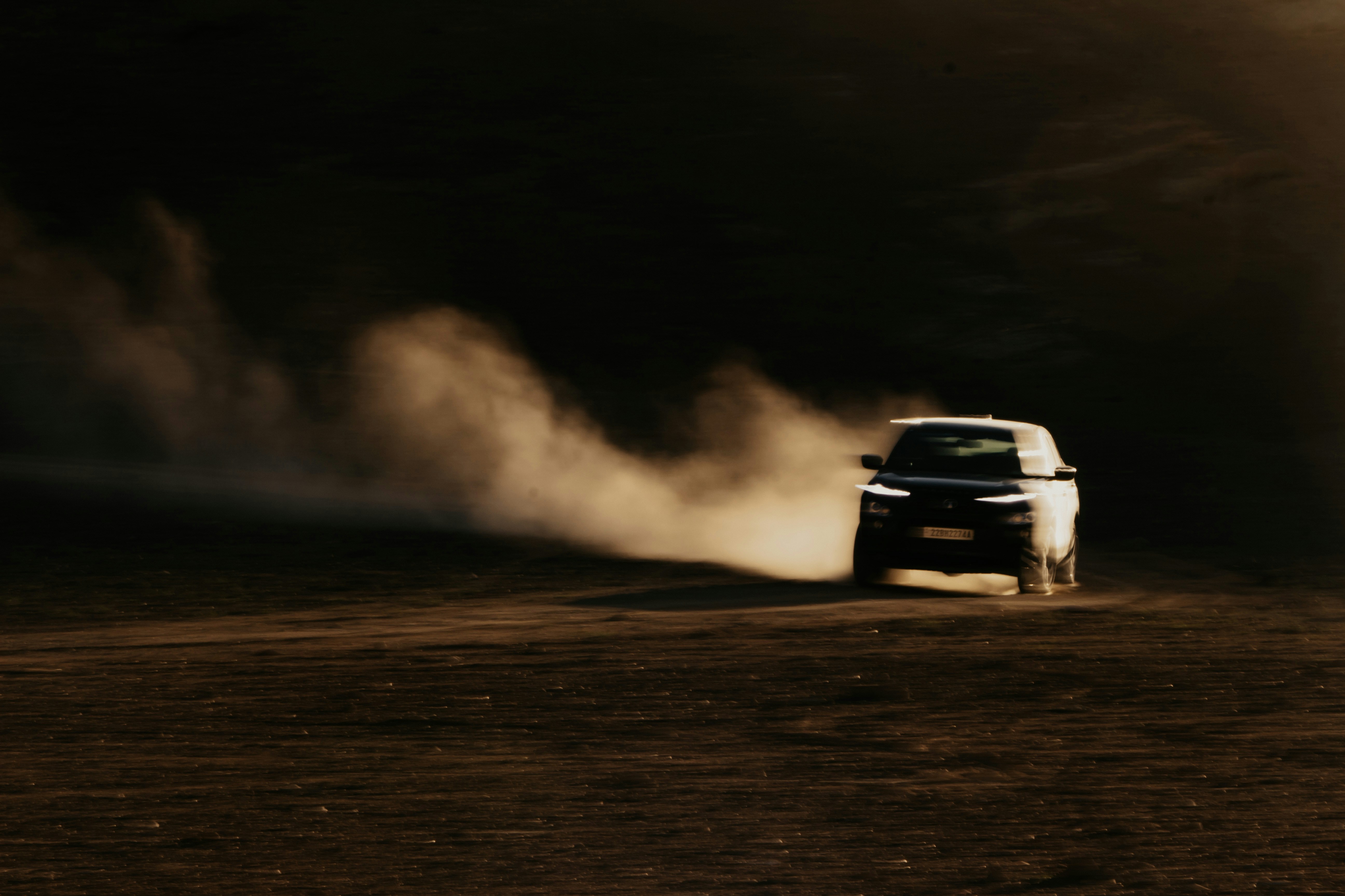 A truck driving down a dirt road at night photo – Free Car Image on ...
