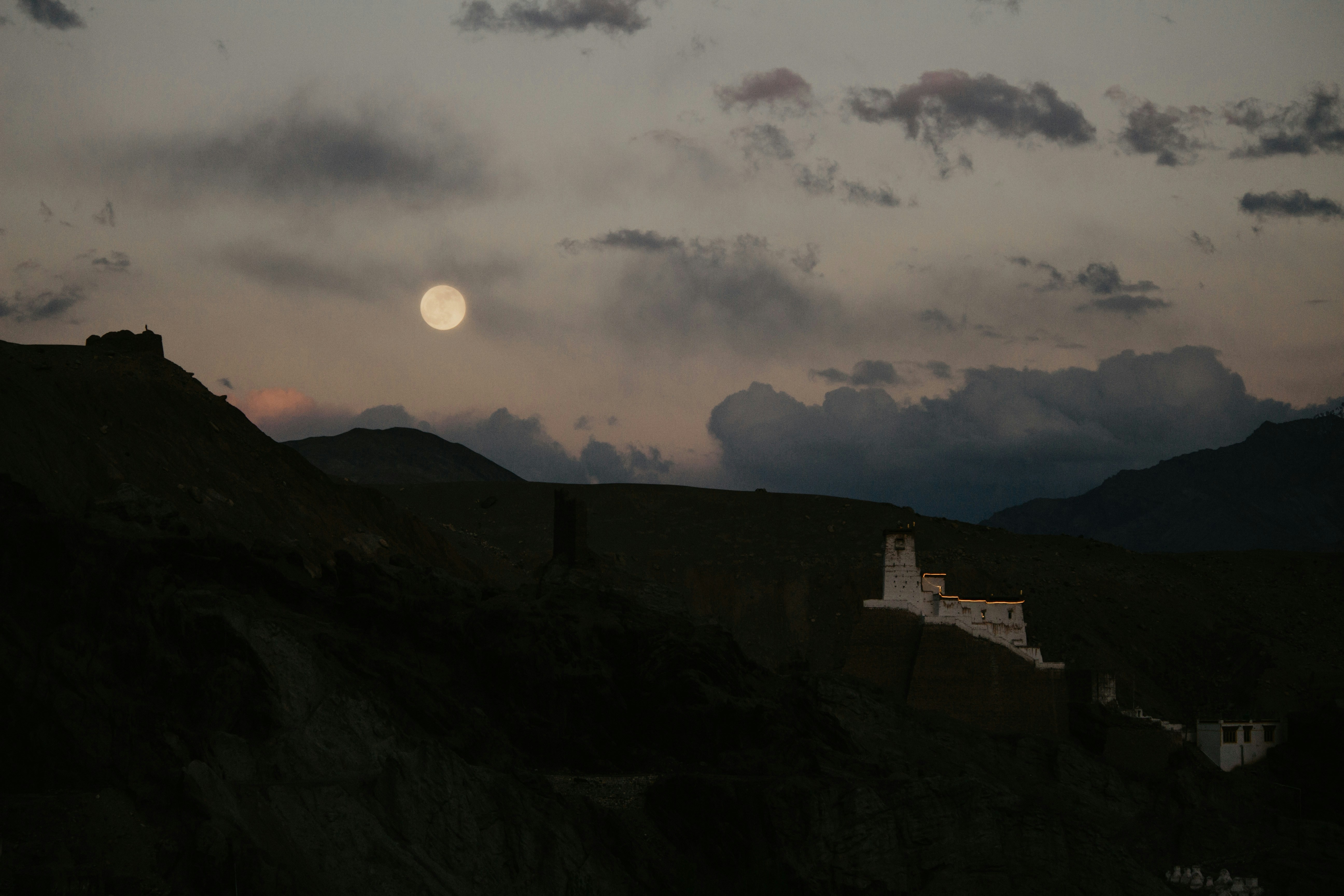 The sun is setting over a hill with a castle on it photo – Free Grey ...