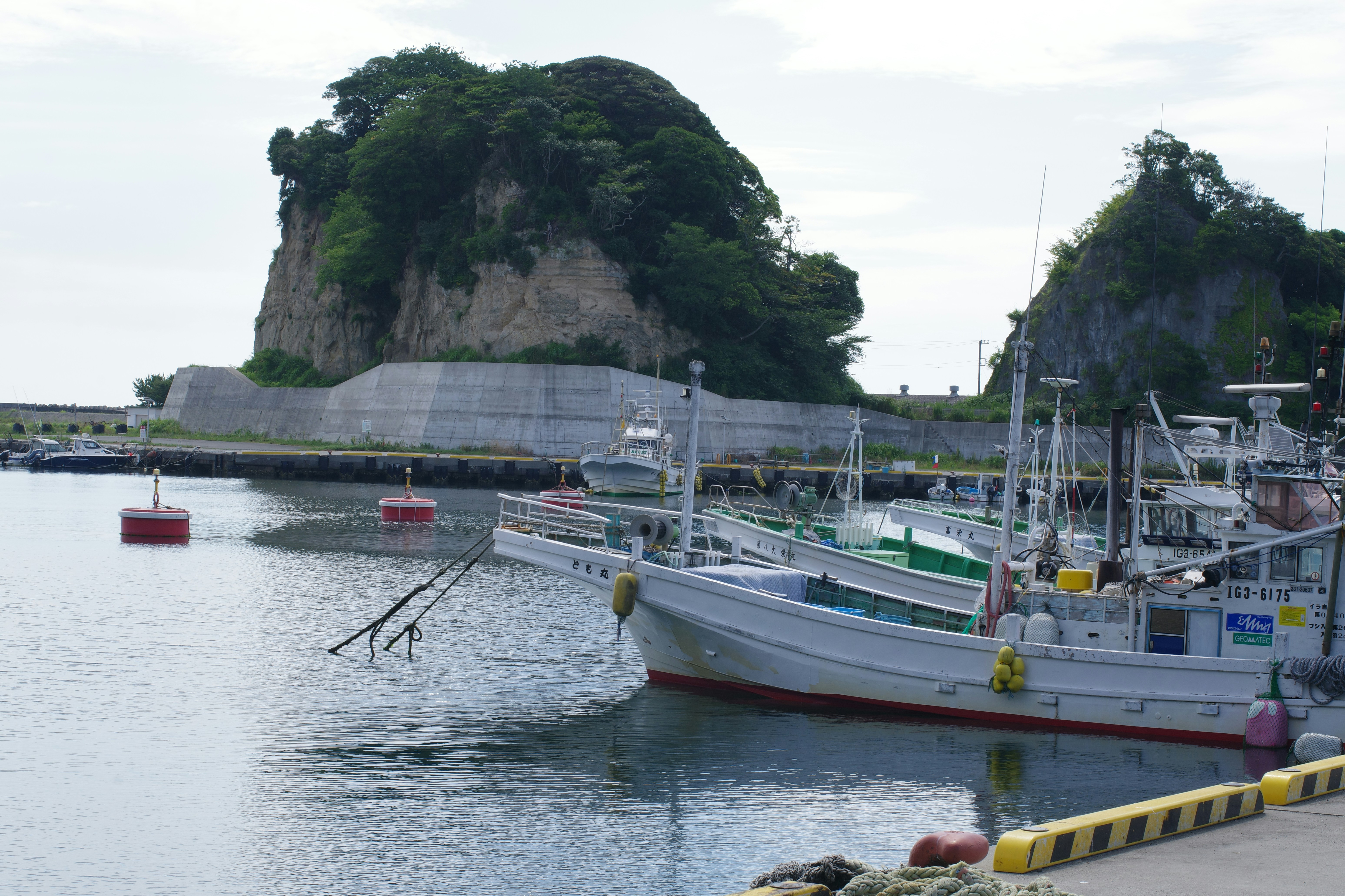 Portside Pause: Boats Rest by a Granite Islet