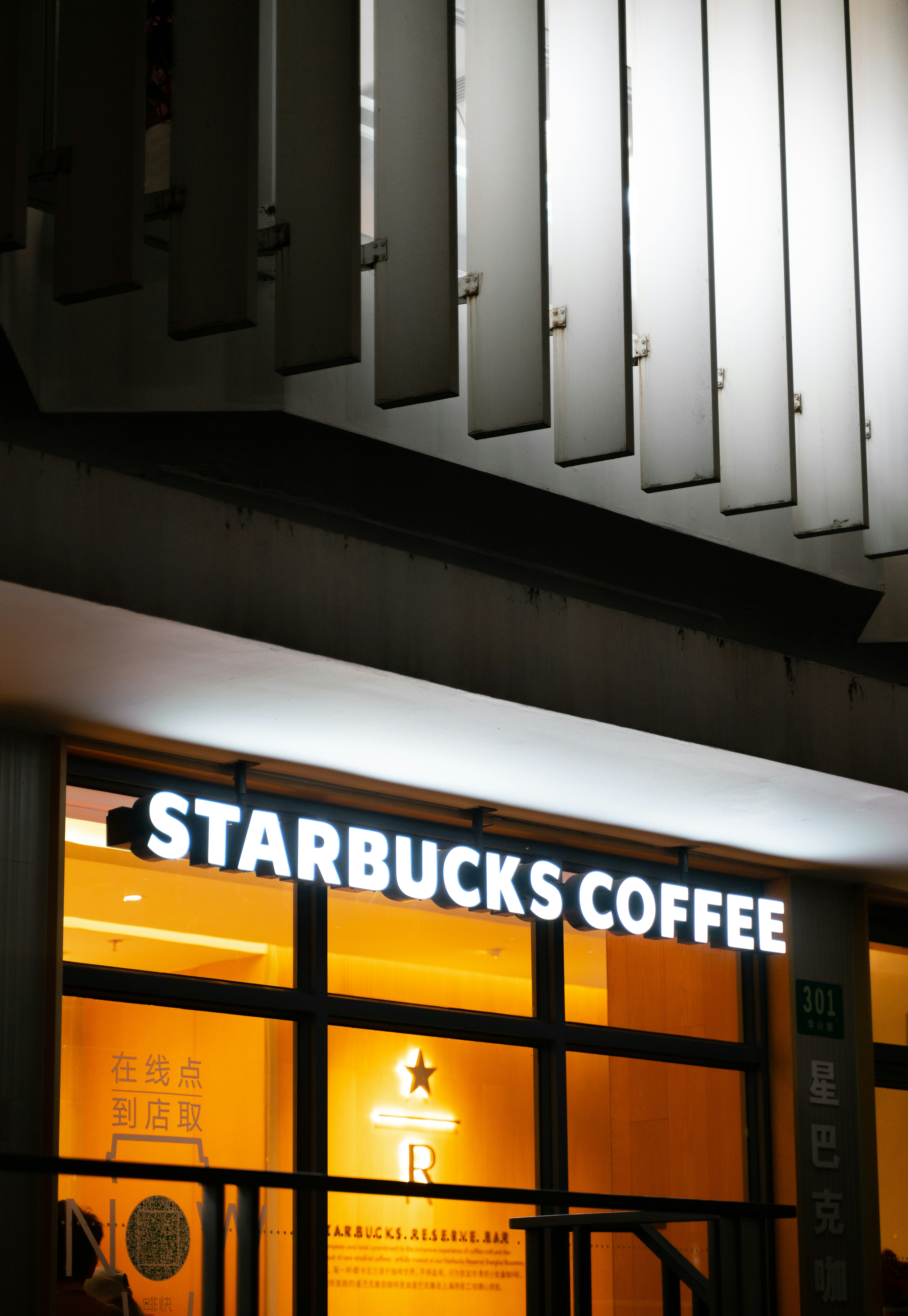 A starbucks coffee shop lit up at night photo – Free Shanghai Image on ...