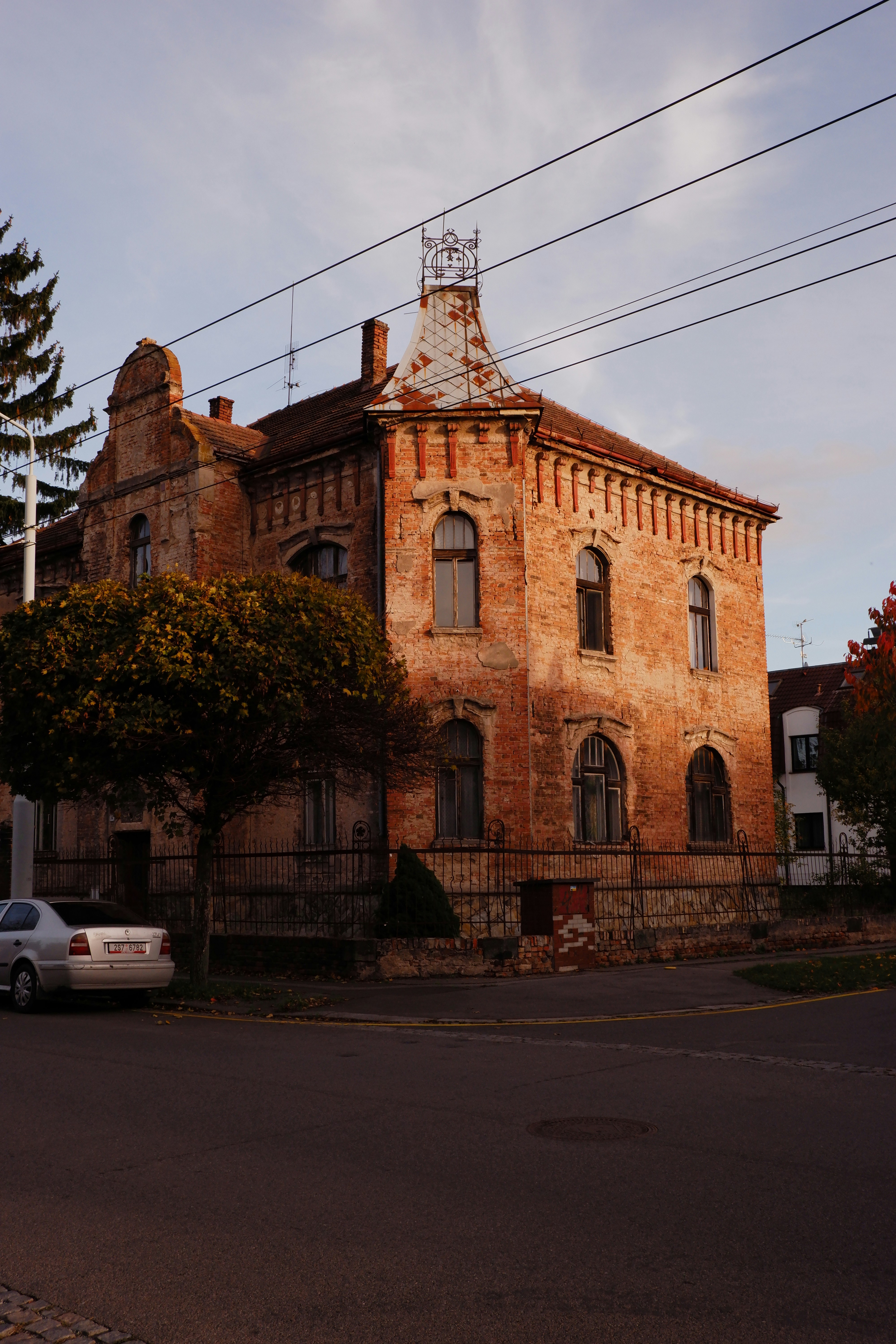Evening Glow on a Historic Brick Villa with Tower and Power Lines