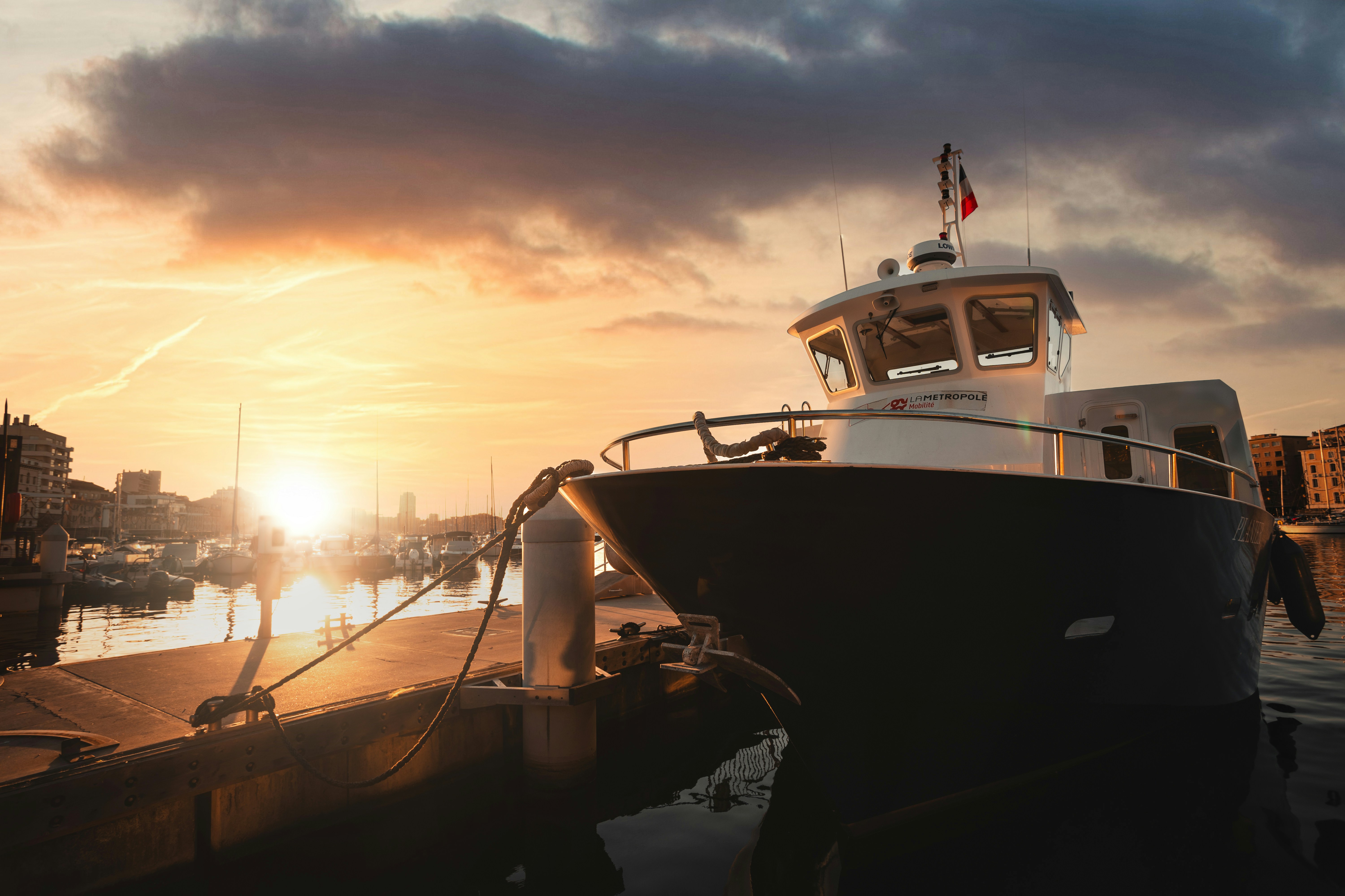 Un bateau amarré dans un port au coucher du soleil photo – Image ...