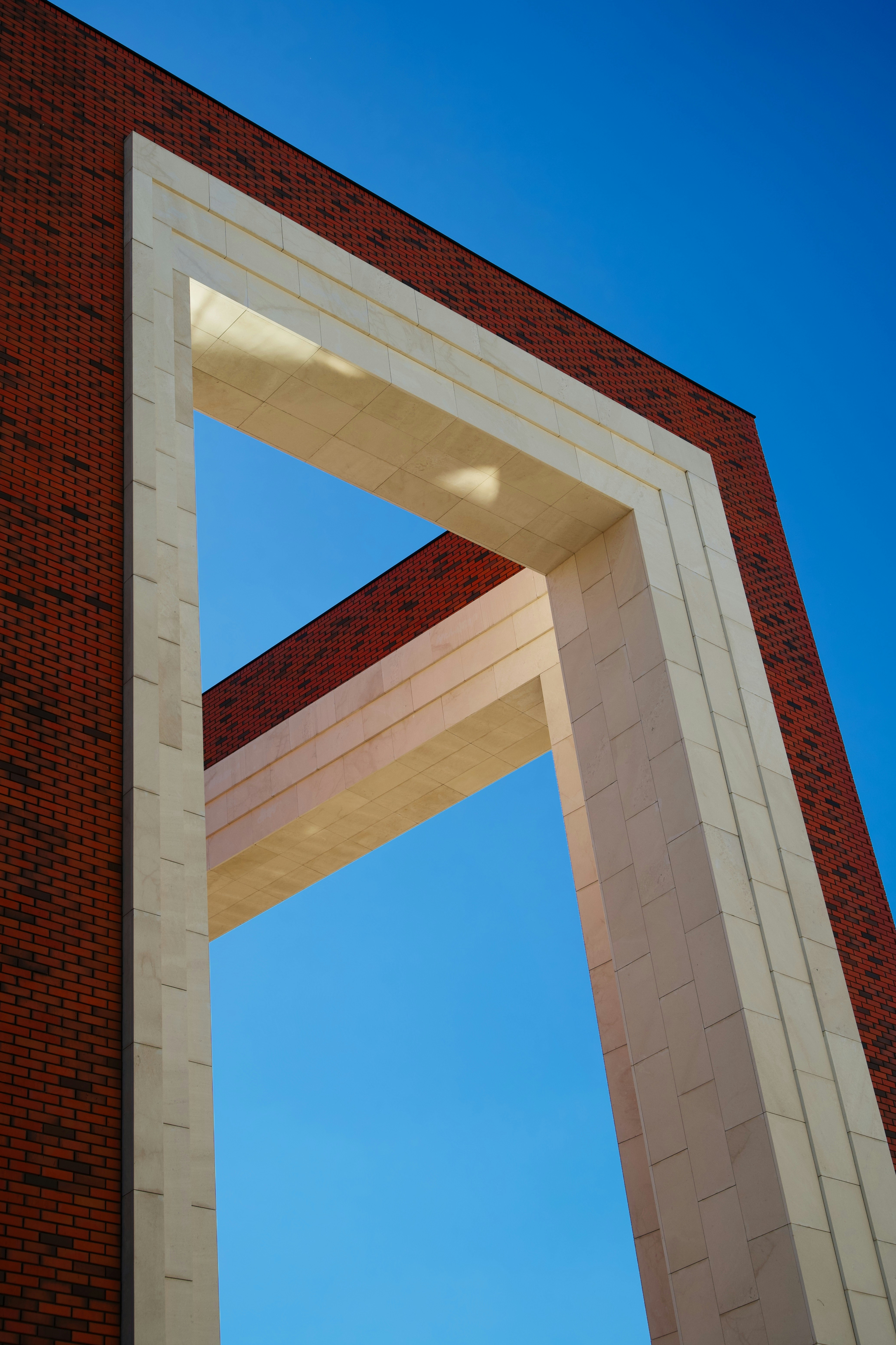 Crimson Brick Frame Framing White Arches Against a Clear Blue Sky