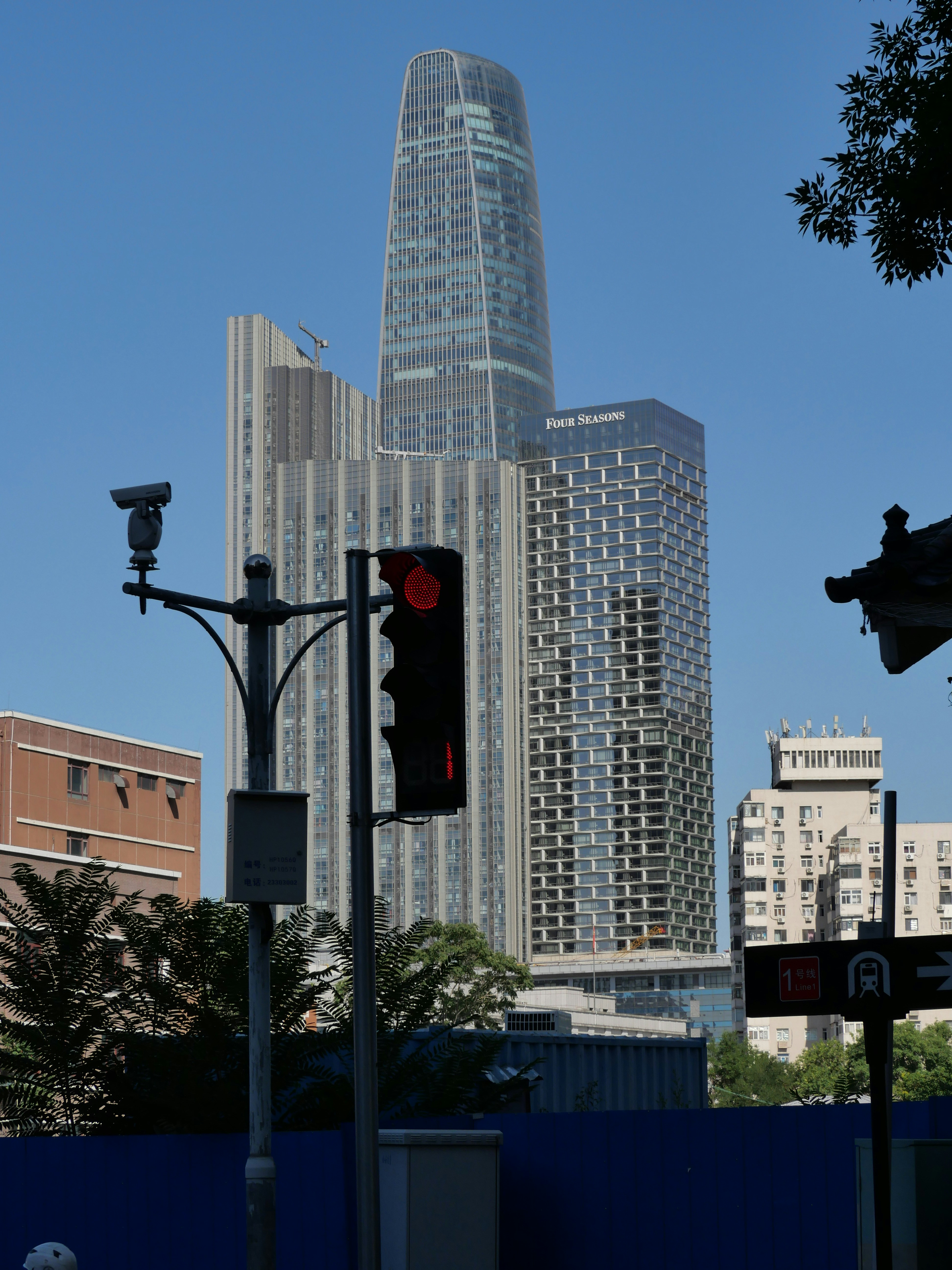 A traffic light on a city street with tall buildings in the background ...
