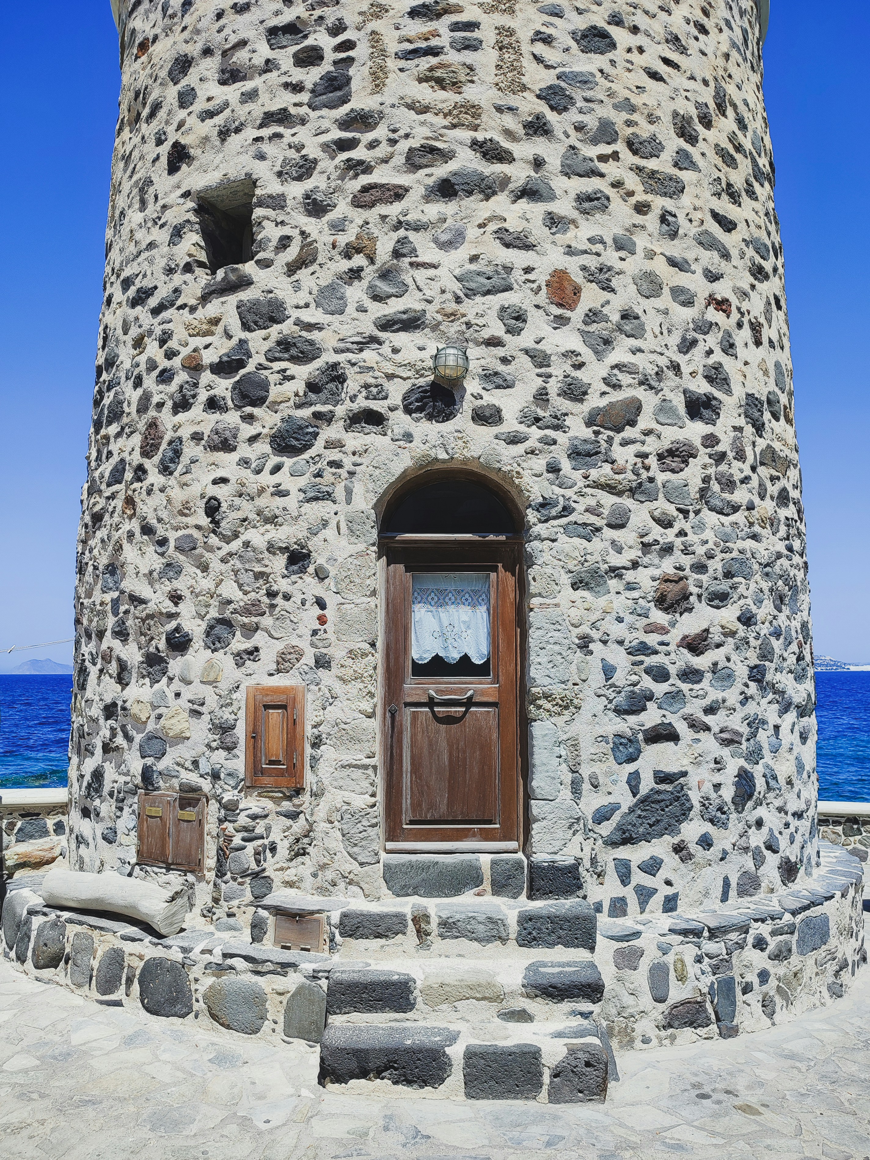 A stone tower with a door and a window photo – Free Sea Image on Unsplash