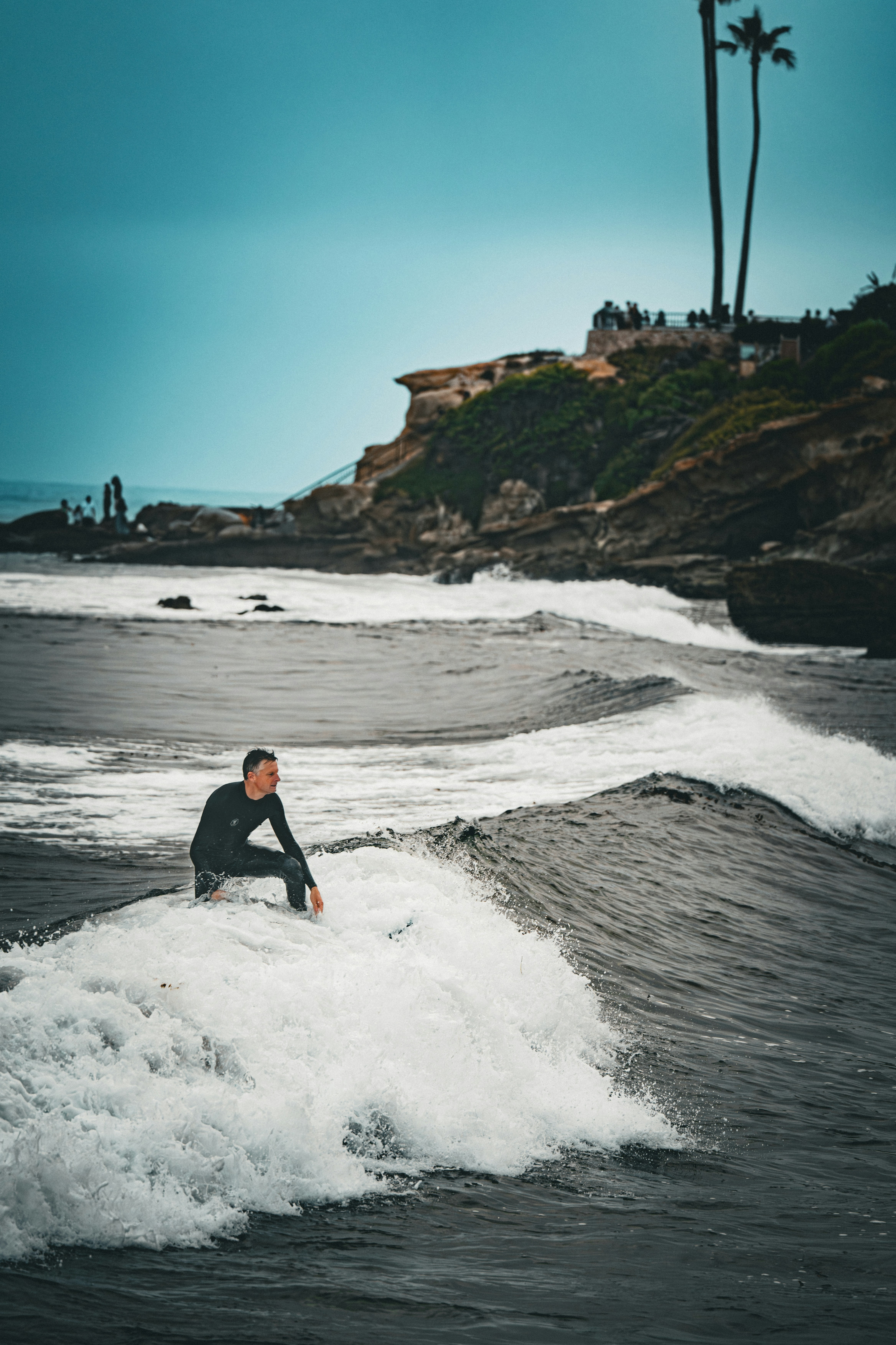 Surfing Silhouette: A Lone Rider Confronts the Break at Coastal Cliffs