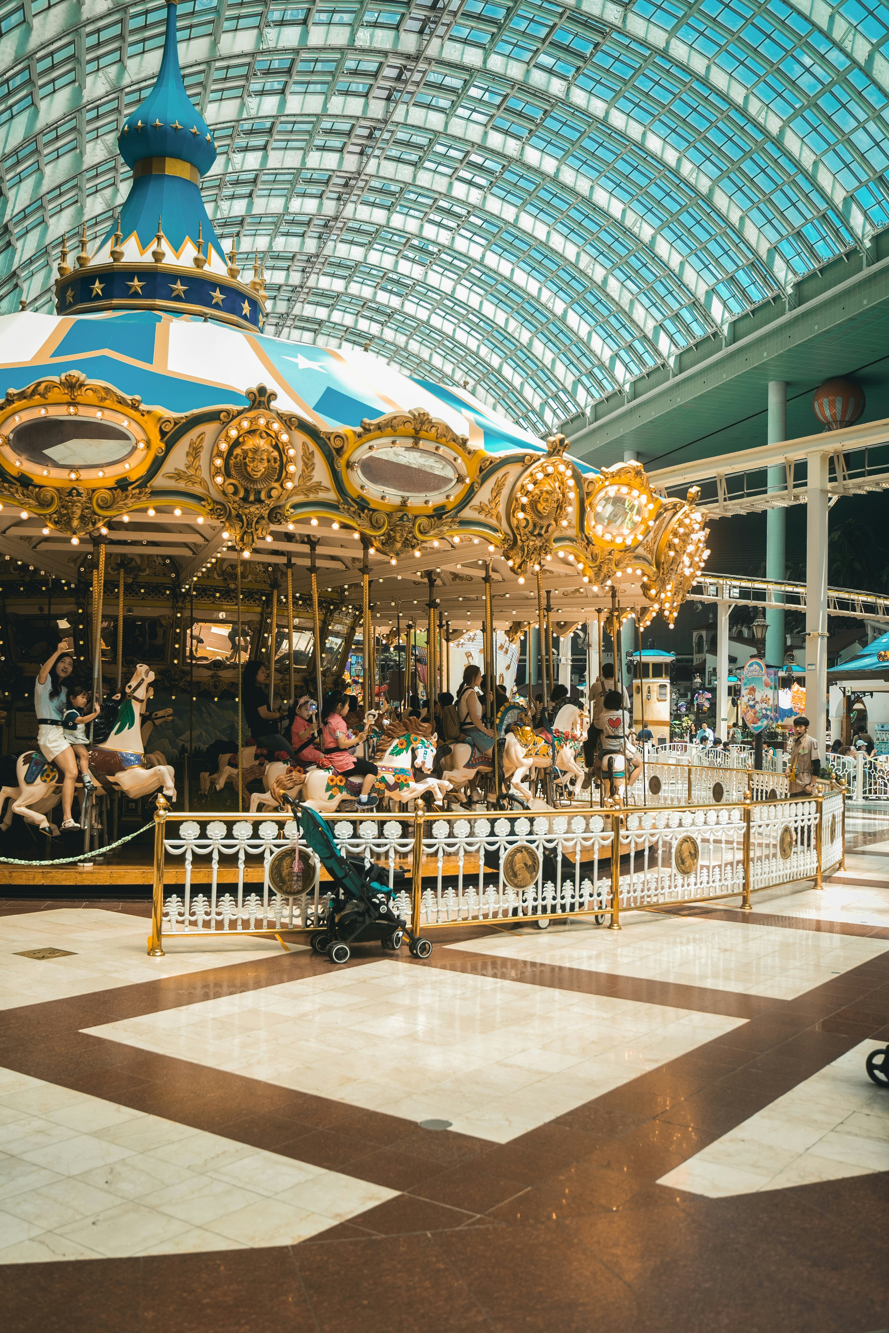 A carousel inside of a building with people sitting on it photo – Free ...
