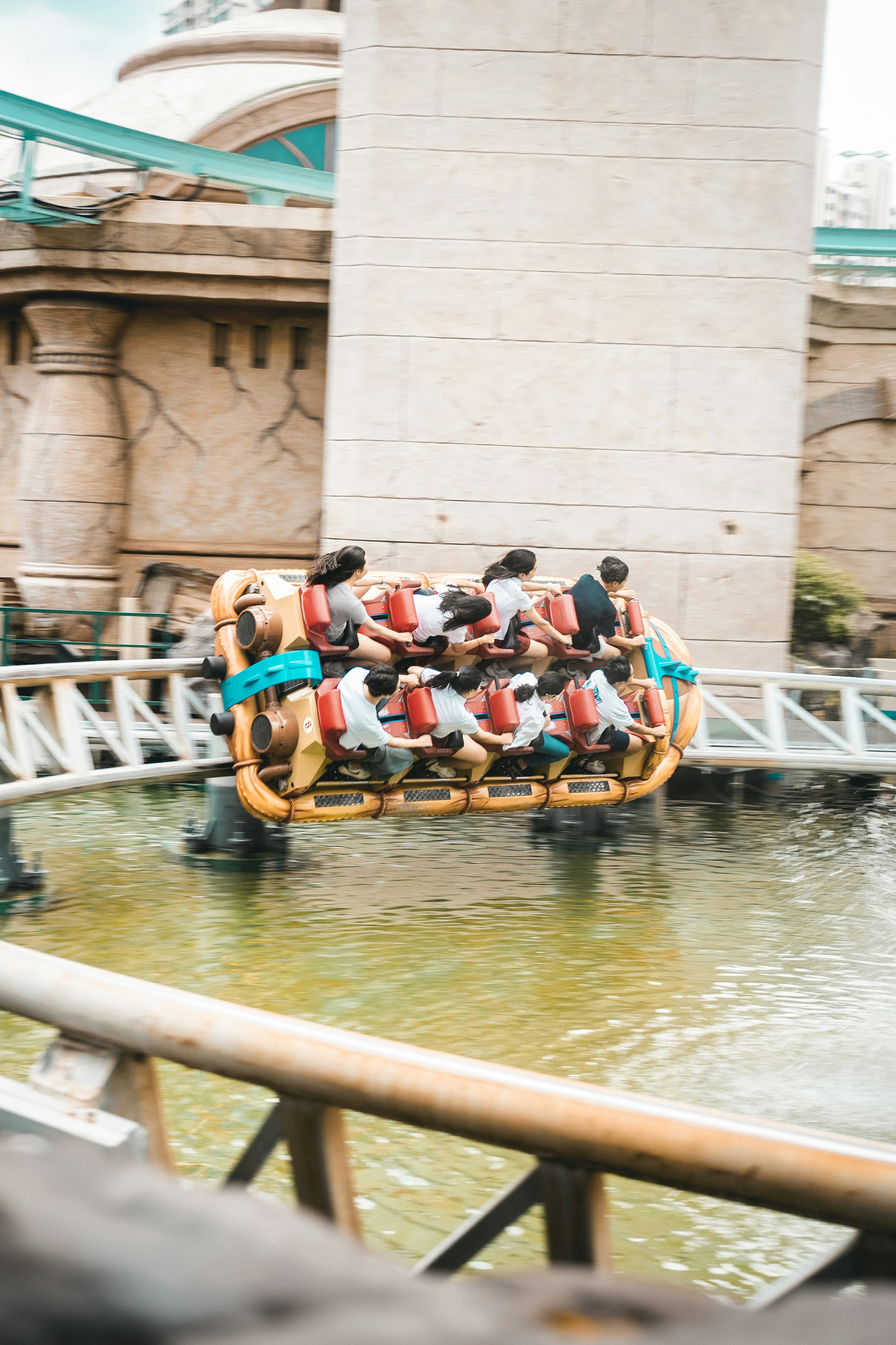 A group of people riding a roller coaster over water photo – Free Human ...