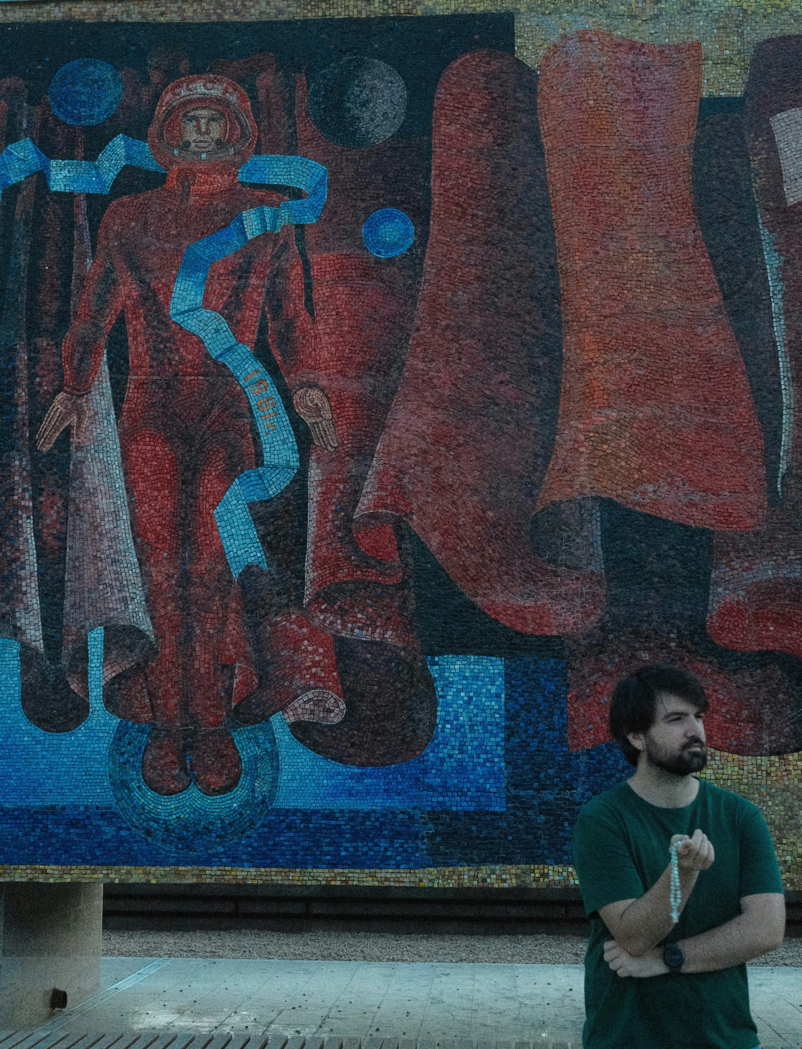 Green-Shirted Figure Anchors a Vast Red-Cloaked Mural