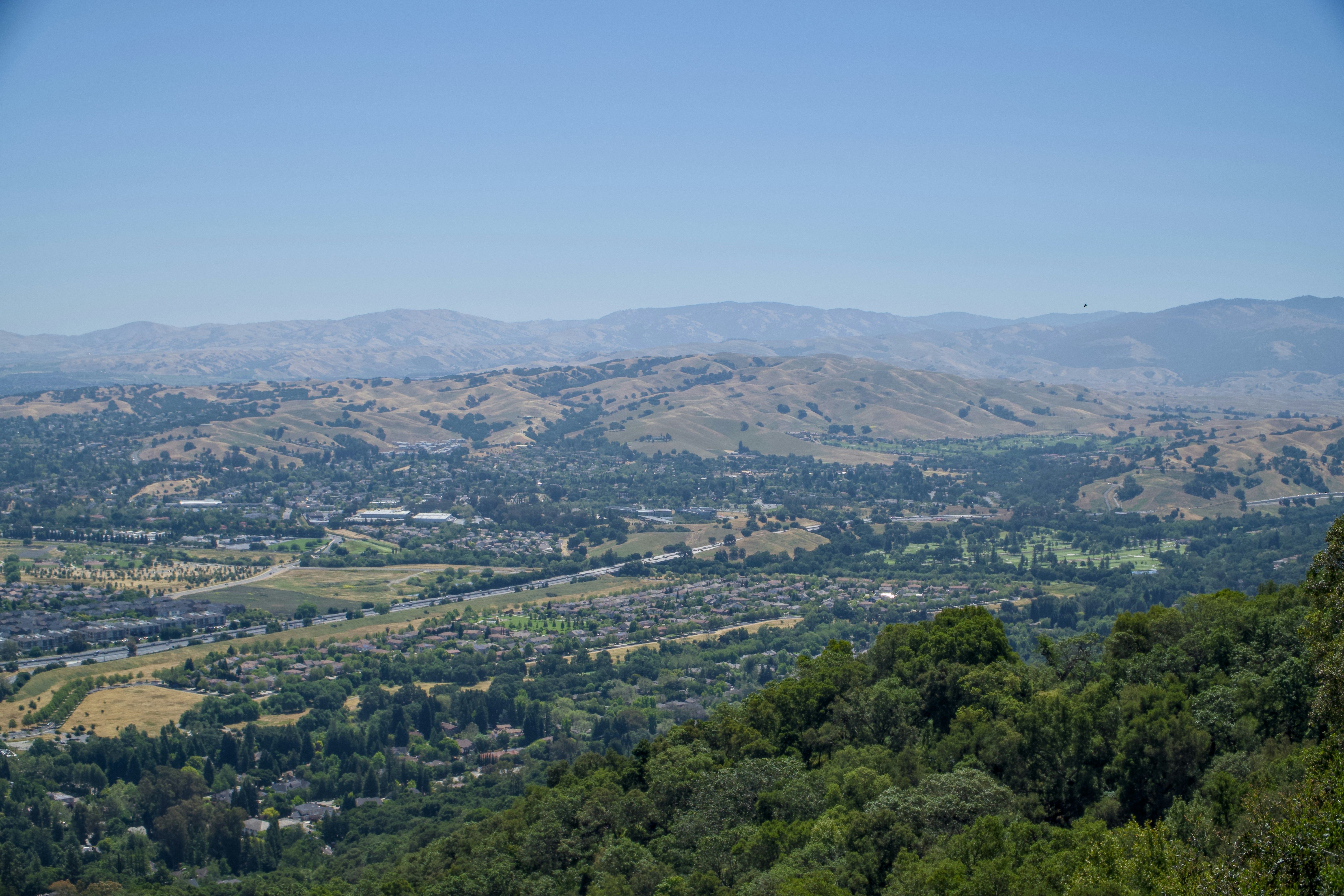 A view of a valley and mountains from the top of a hill photo – Free ...