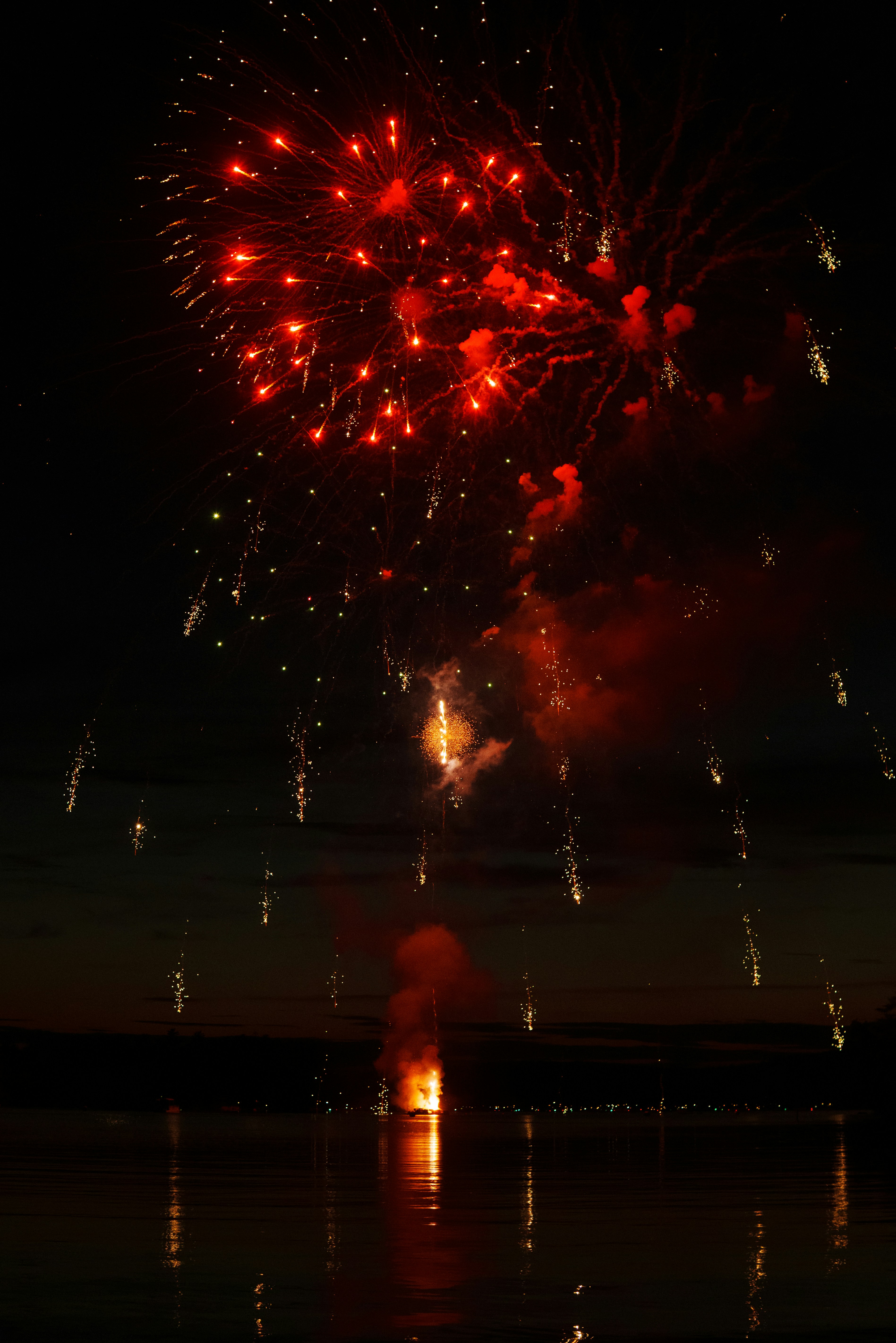 A firework display in the night sky over a body of water photo – Free Brown Image on Unsplash