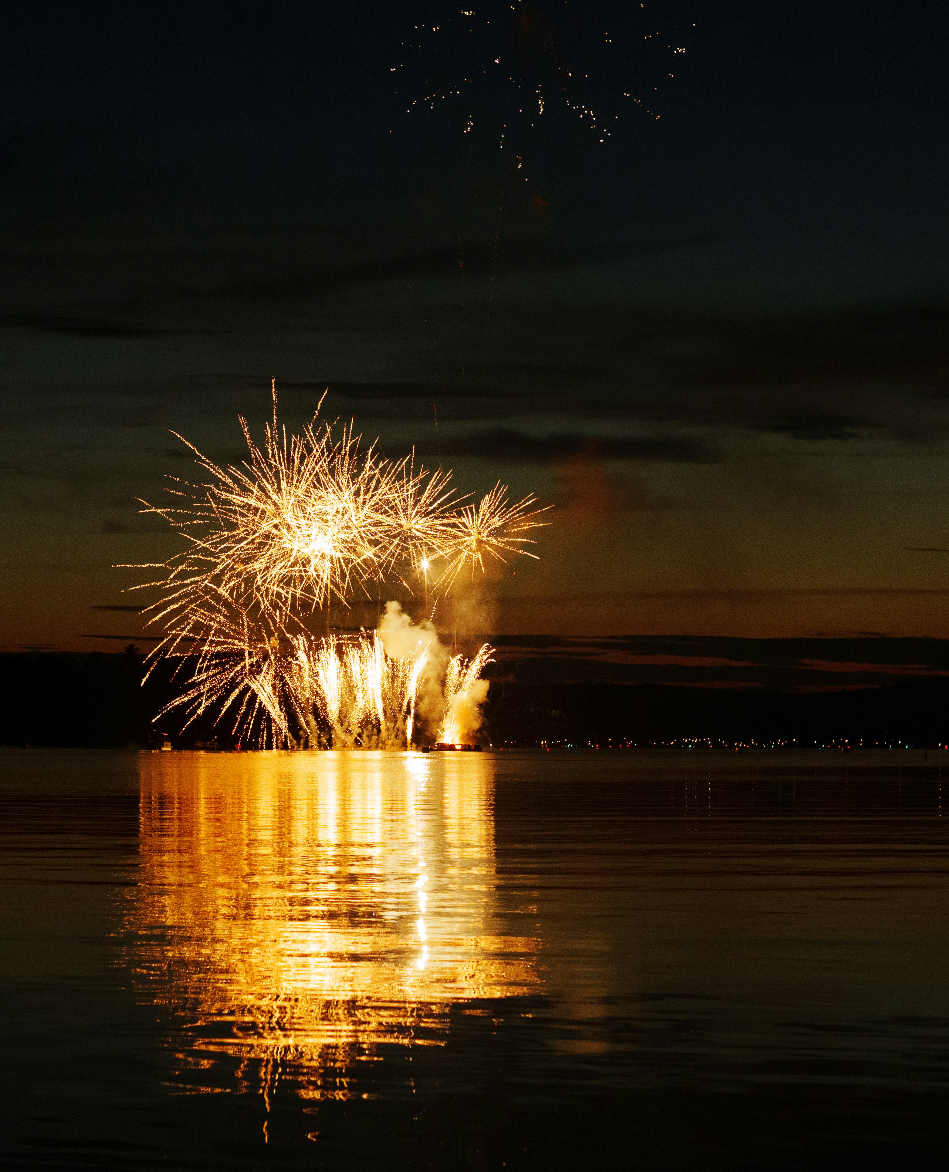 A firework display on a lake at night photo – Free Brown Image on Unsplash