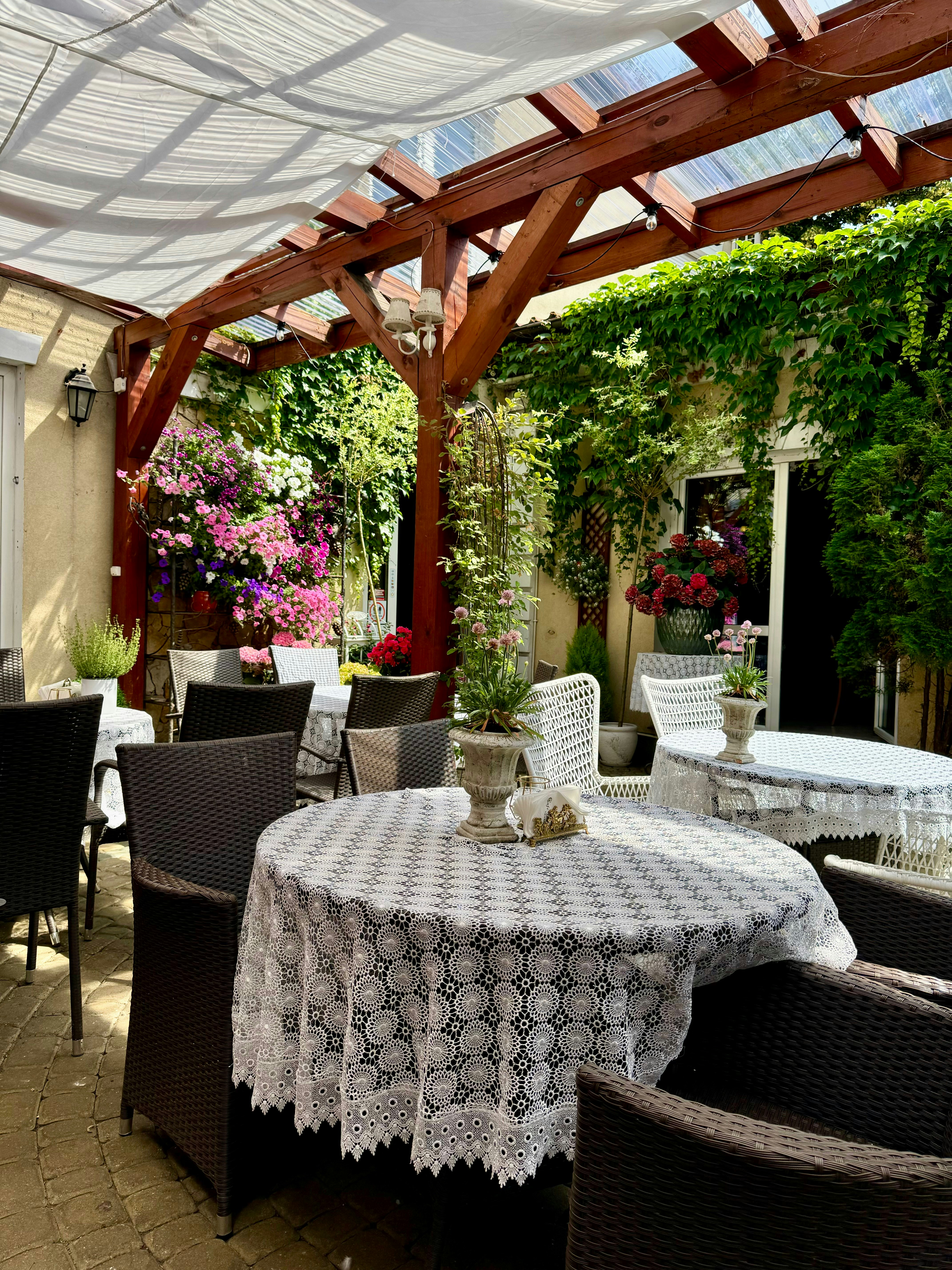 A patio with tables and chairs and a pergolated roof photo – Free ...