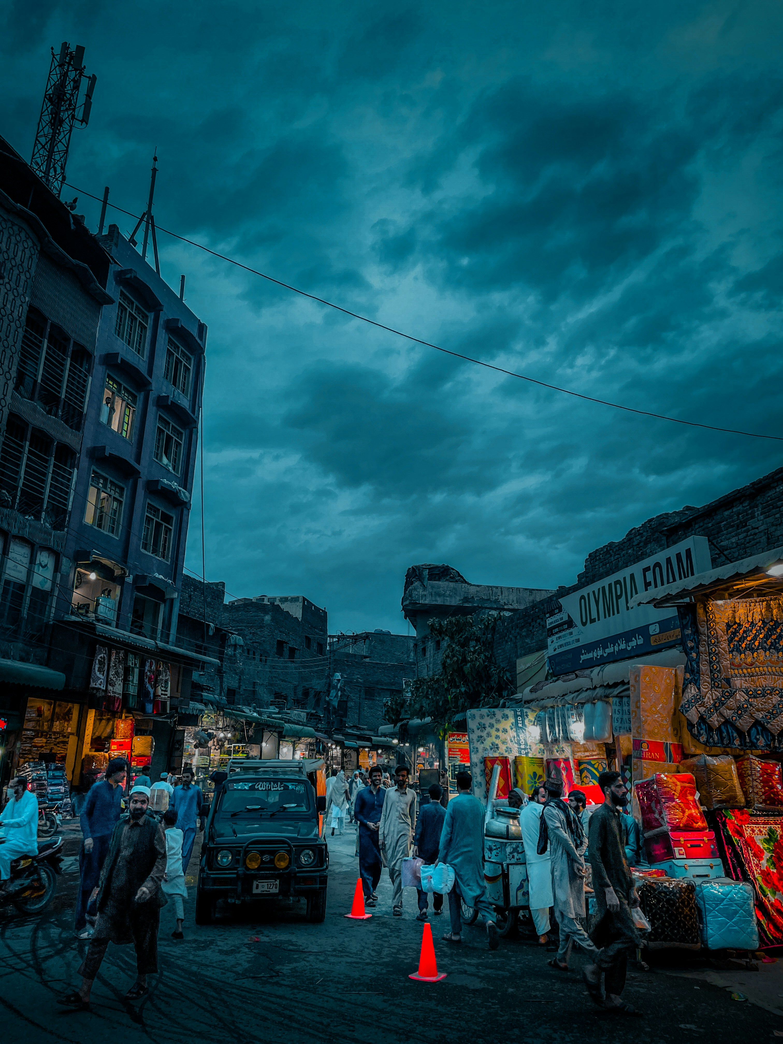 Indigo Market Pulse: Vendors, Cones, and a Jeep Under a Stormy Blue Sky