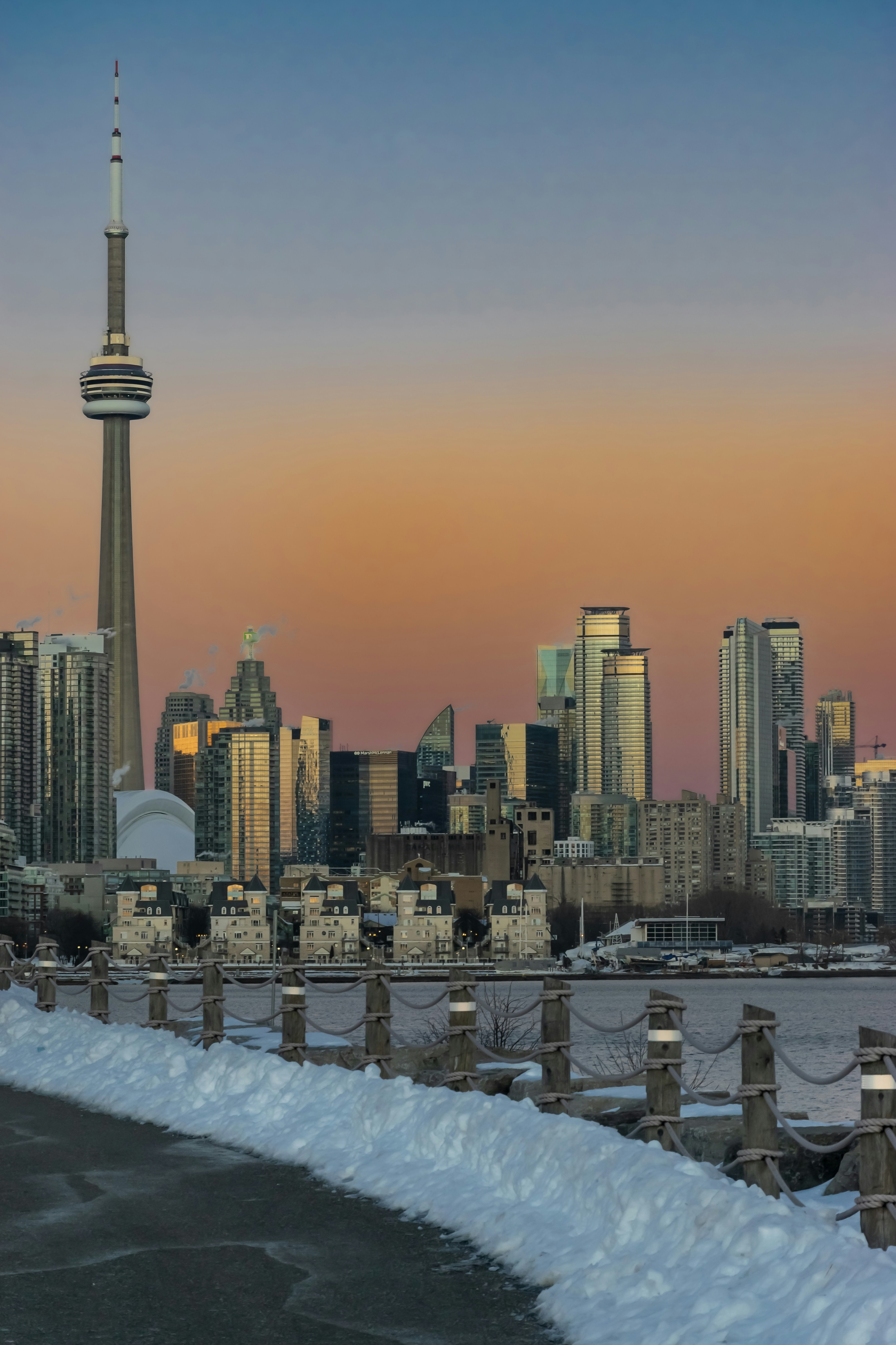 Dusk Over Icebound Waterfront: Toronto's CN Tower at Sunset