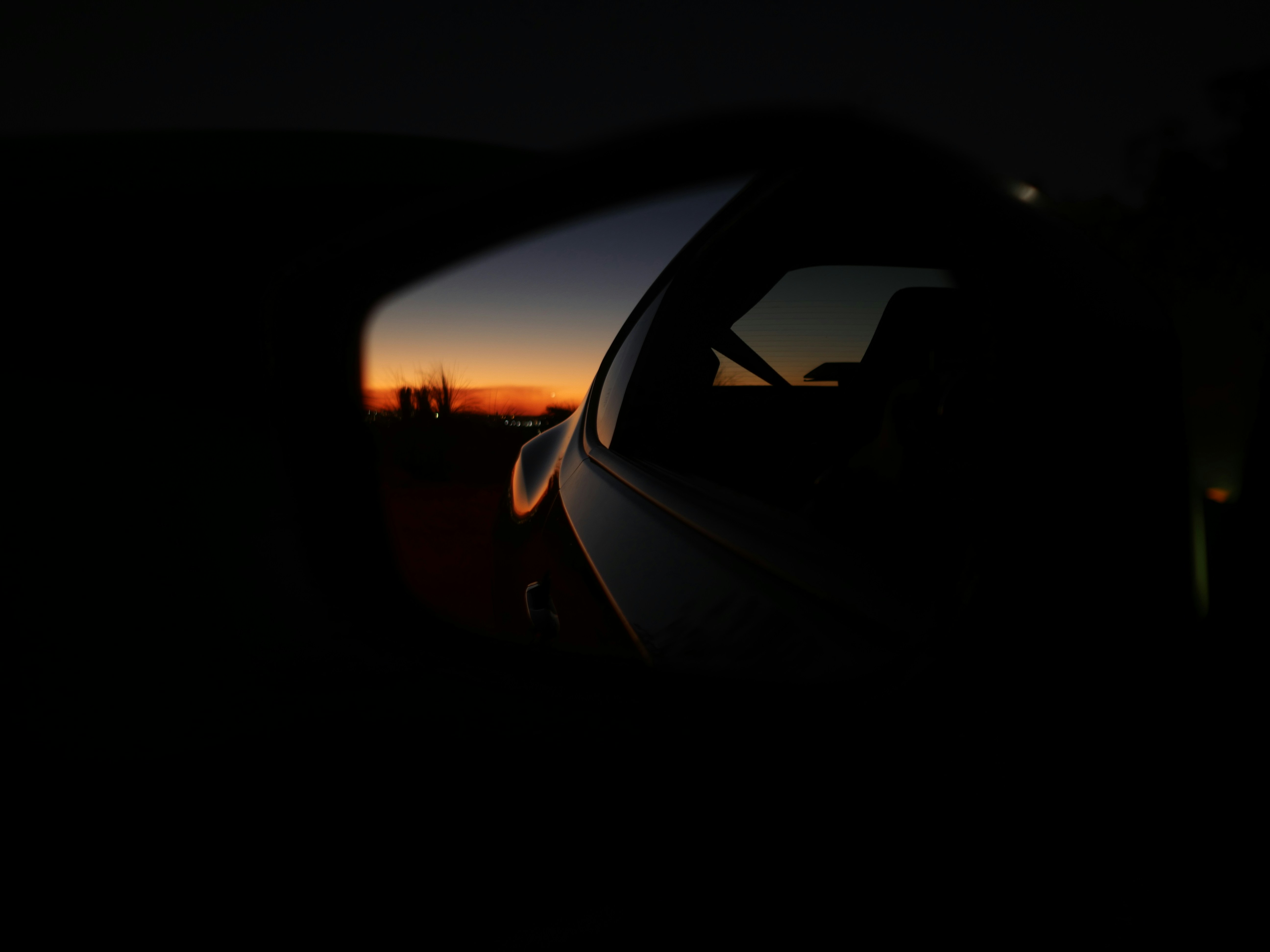Dusk in the Mirror: An Orange Horizon Reflected in a Car's Side View