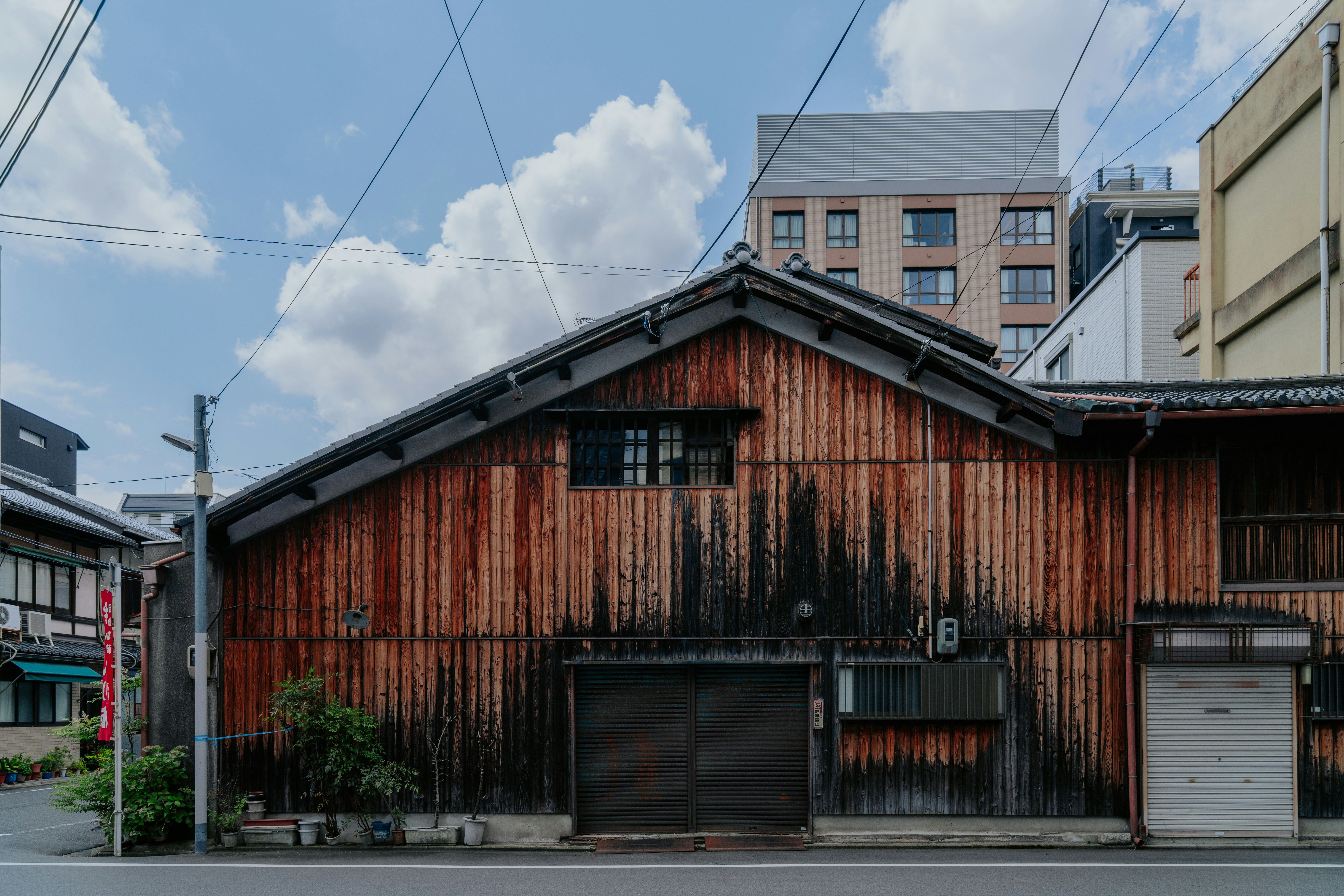 Charred Timber Warehouse Front Framed by a Modern Cityscape