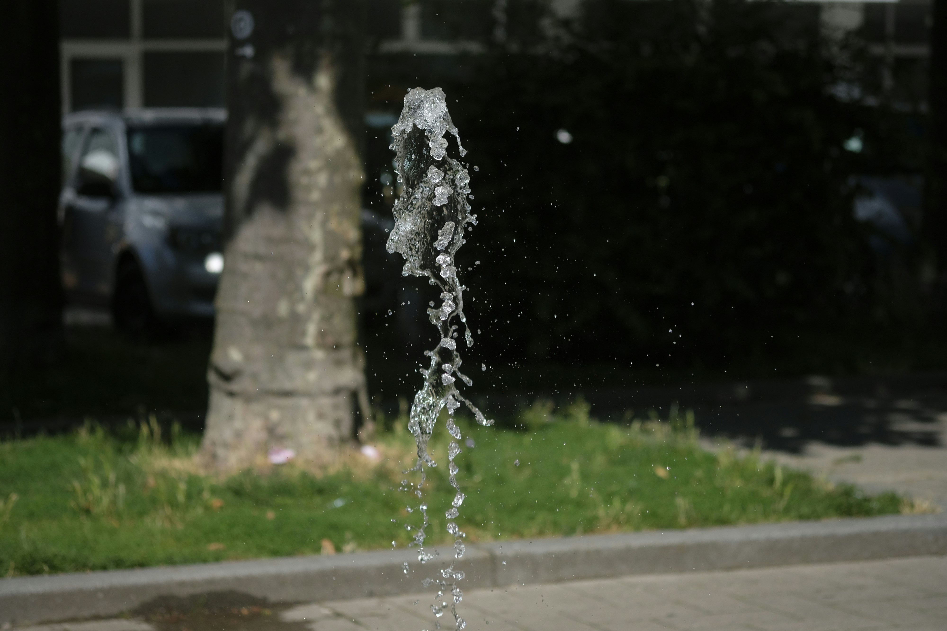 A fire hydrant spewing water on a sidewalk photo – Free Car Image on ...