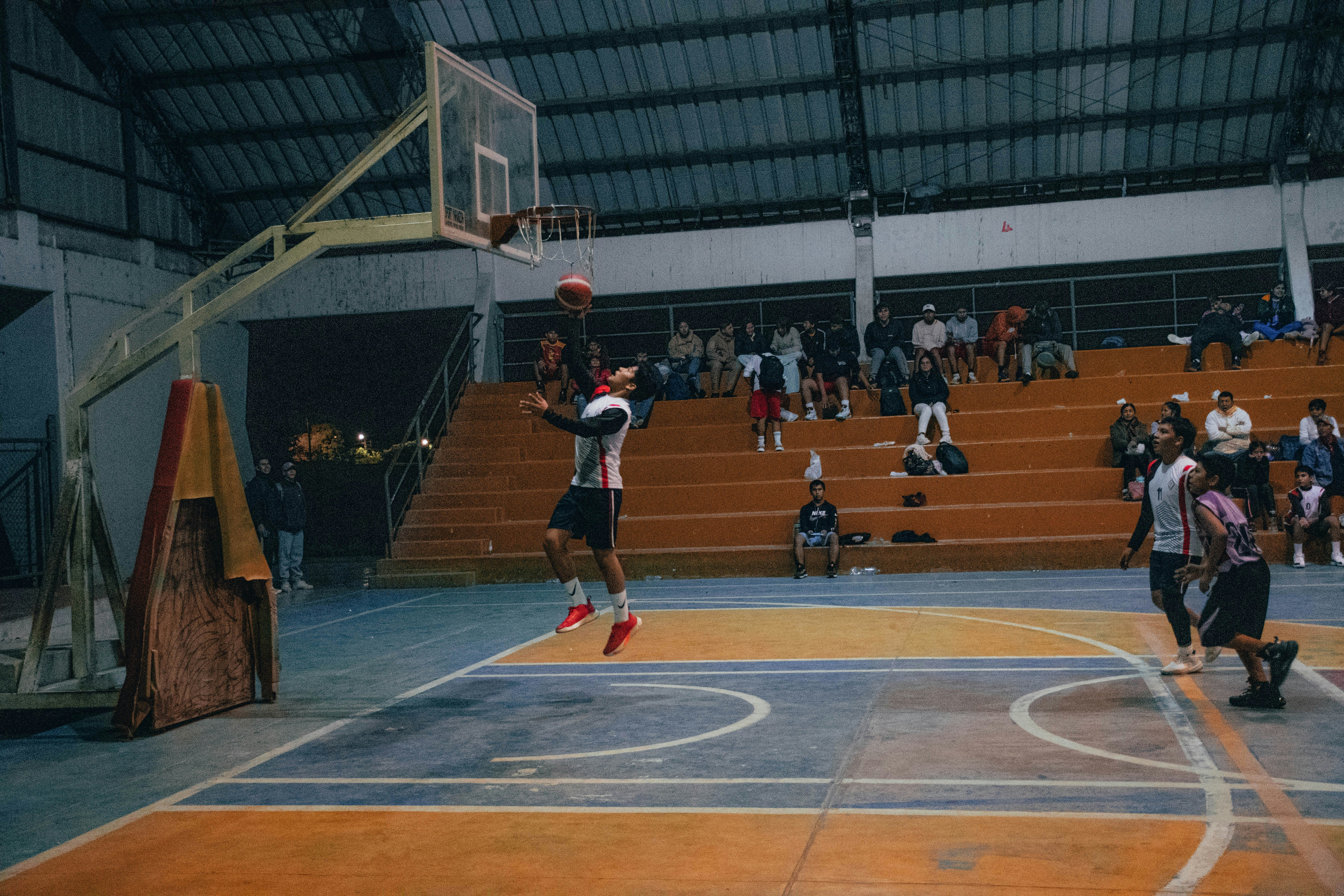 A group of young men playing a game of basketball photo – Free Human ...