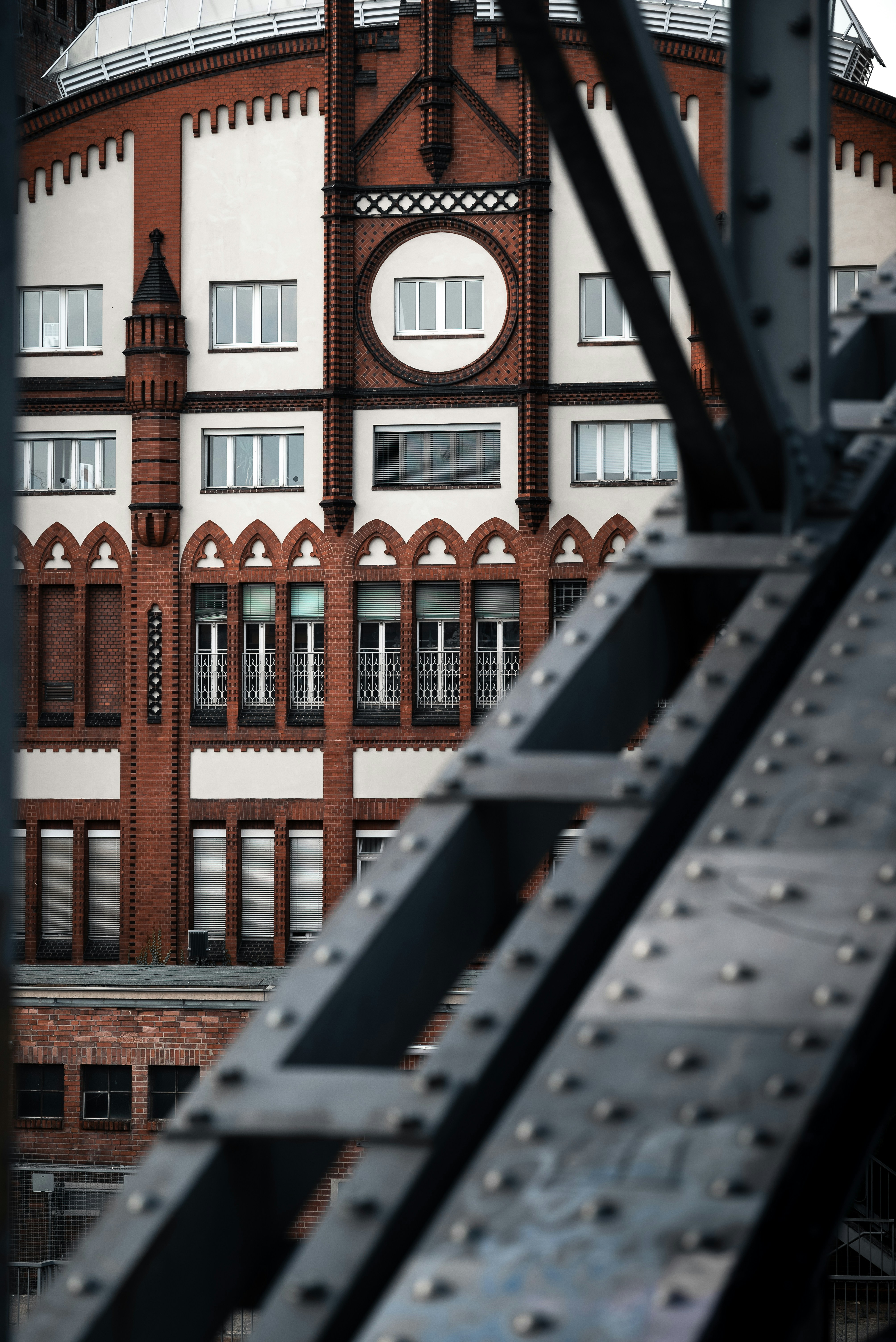 Round Window on a Red Brick Facade Framed by Steel Arches