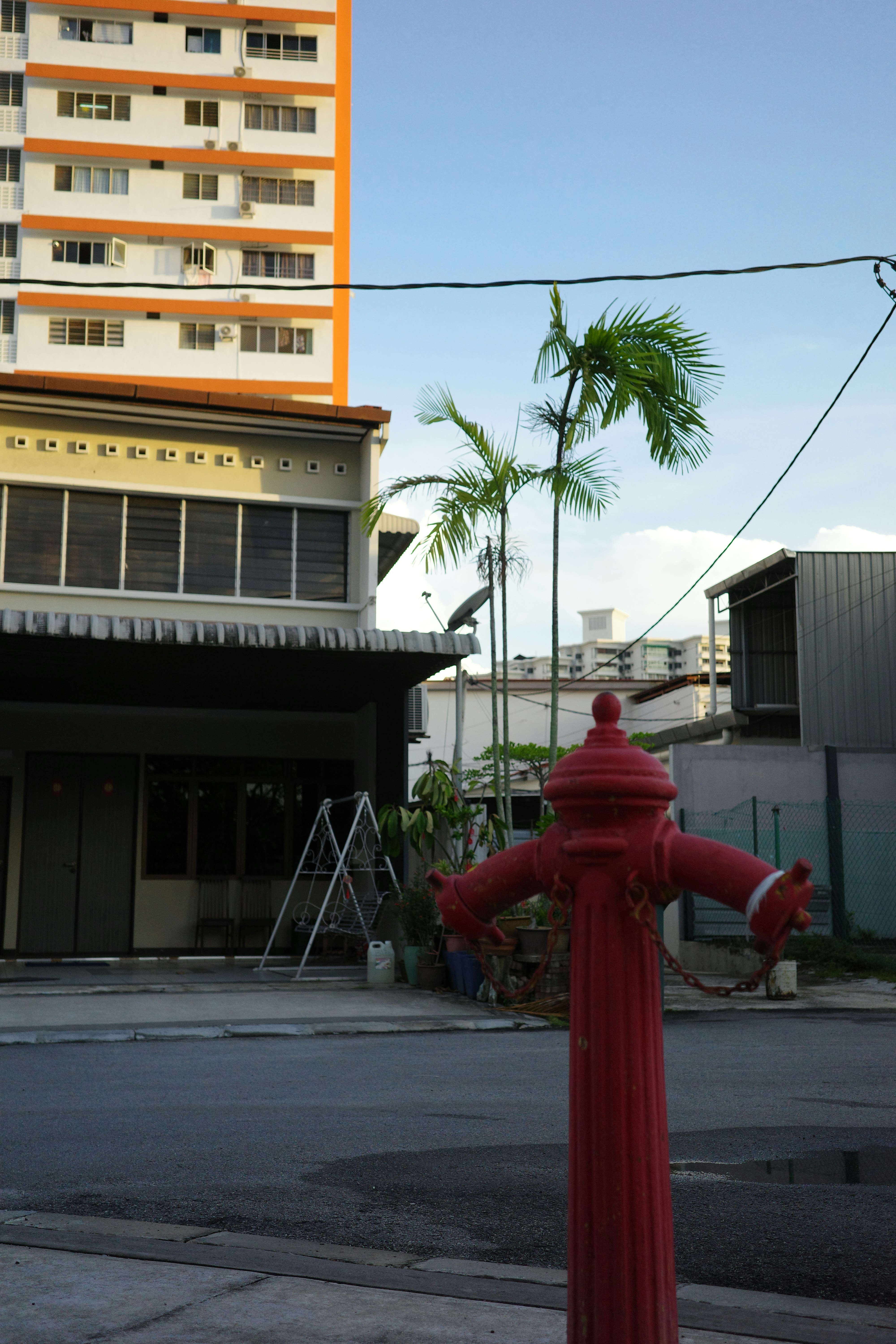 Crimson Hydrant Framing a Sunlit Urban Slice