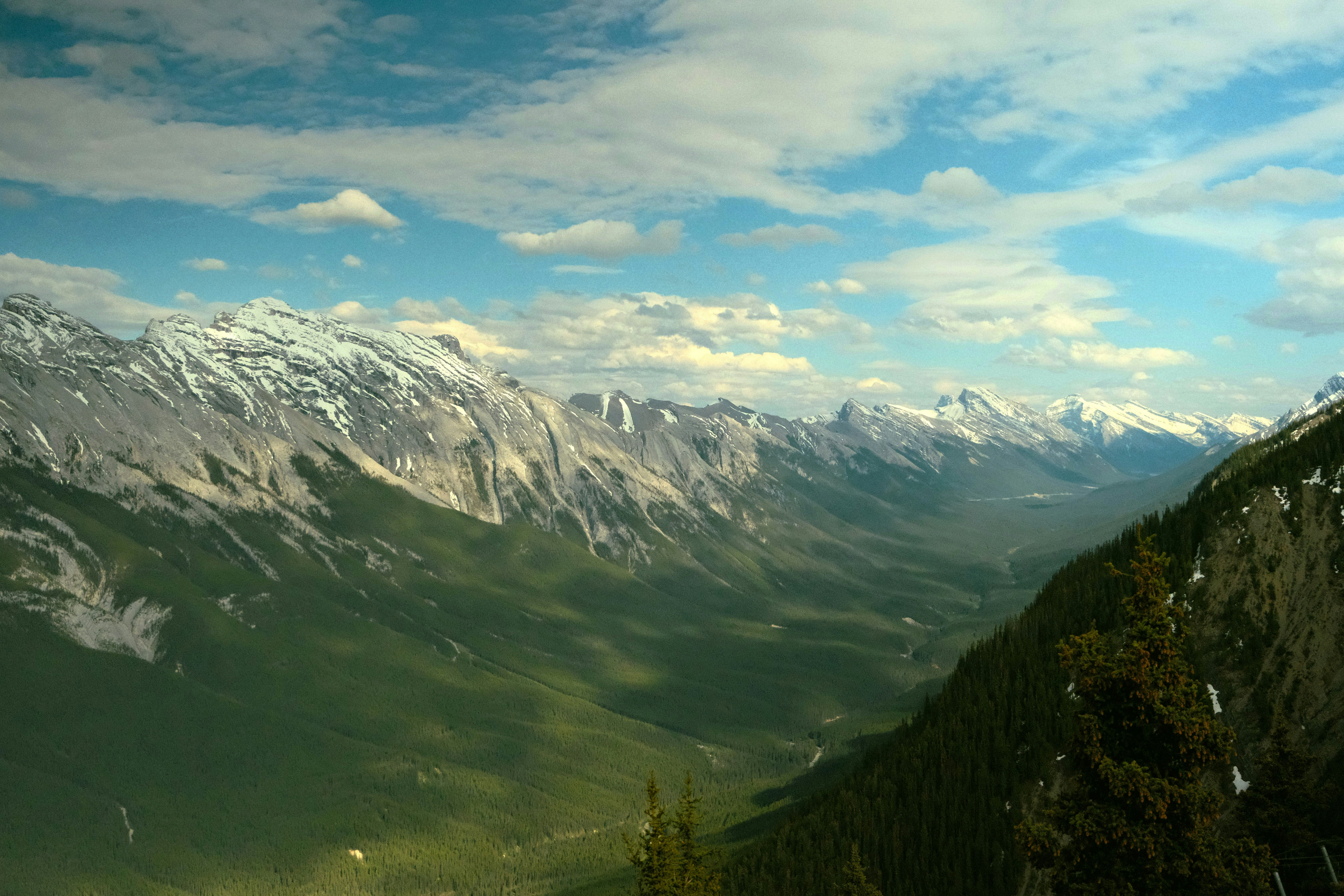 A man standing on top of a mountain overlooking a valley photo – Free ...
