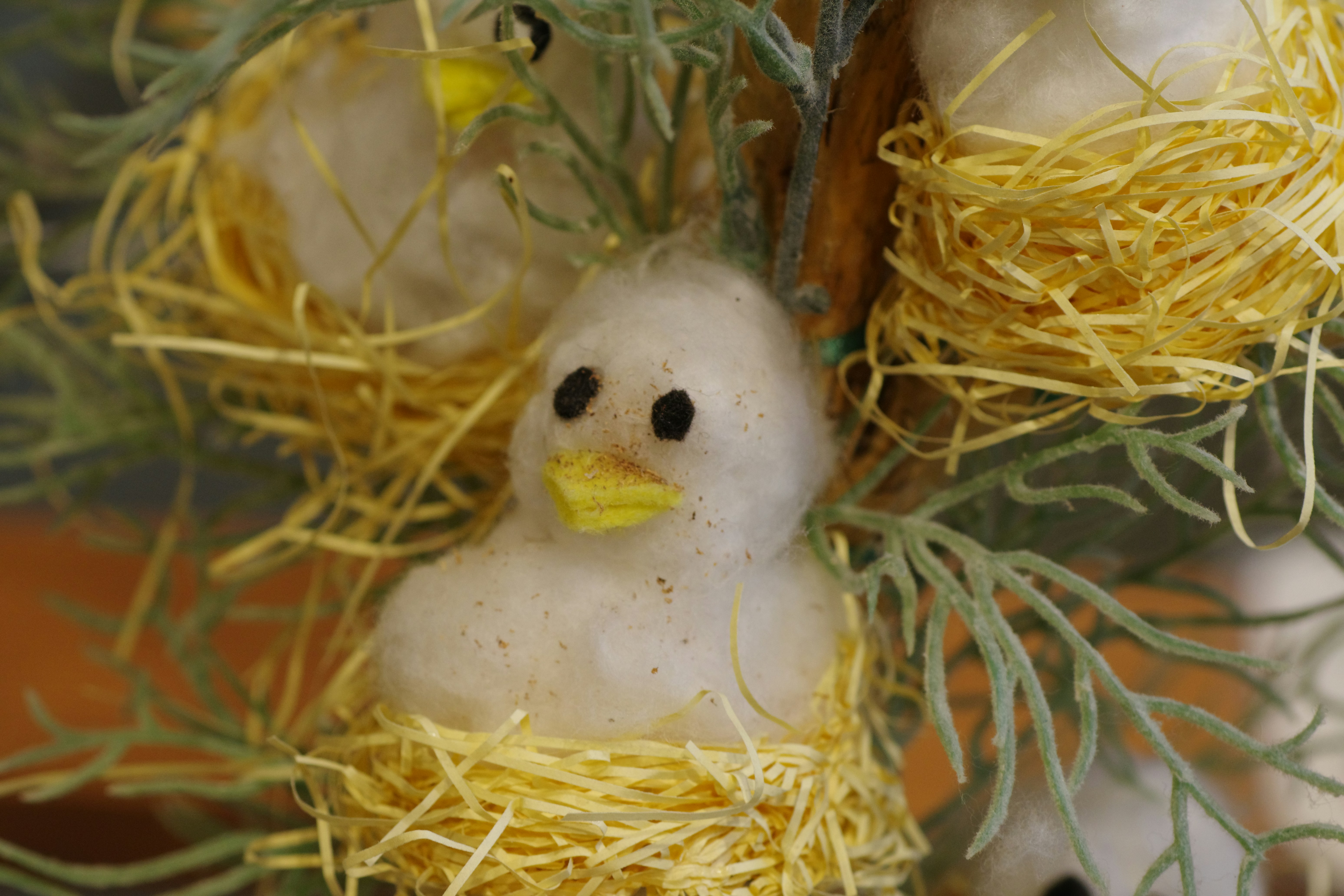 Fluff in a Straw Nest: A Tiny Chick Peeks Through Golden Tangle
