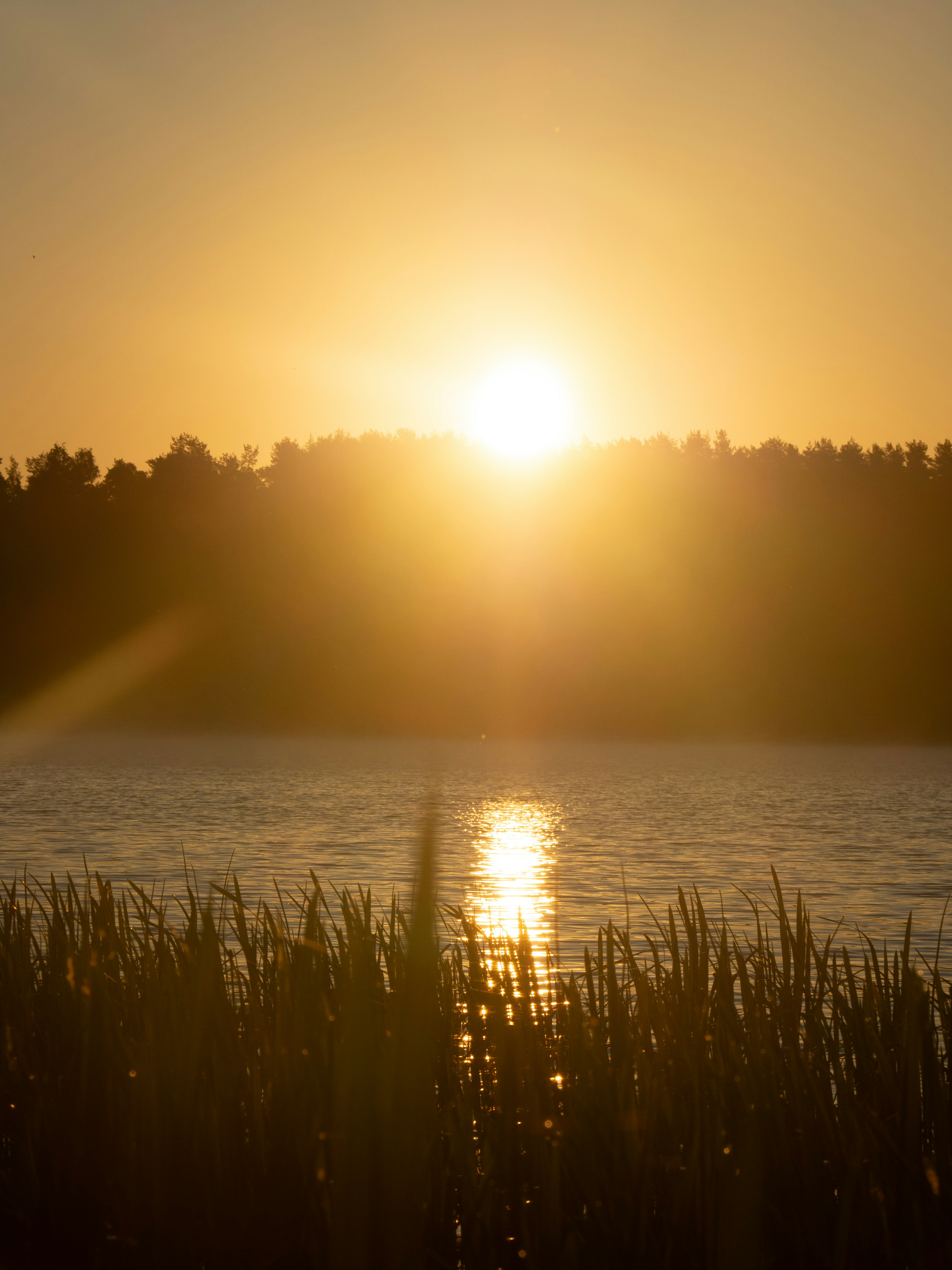The sun is setting over a body of water photo – Free Sunset Image on ...