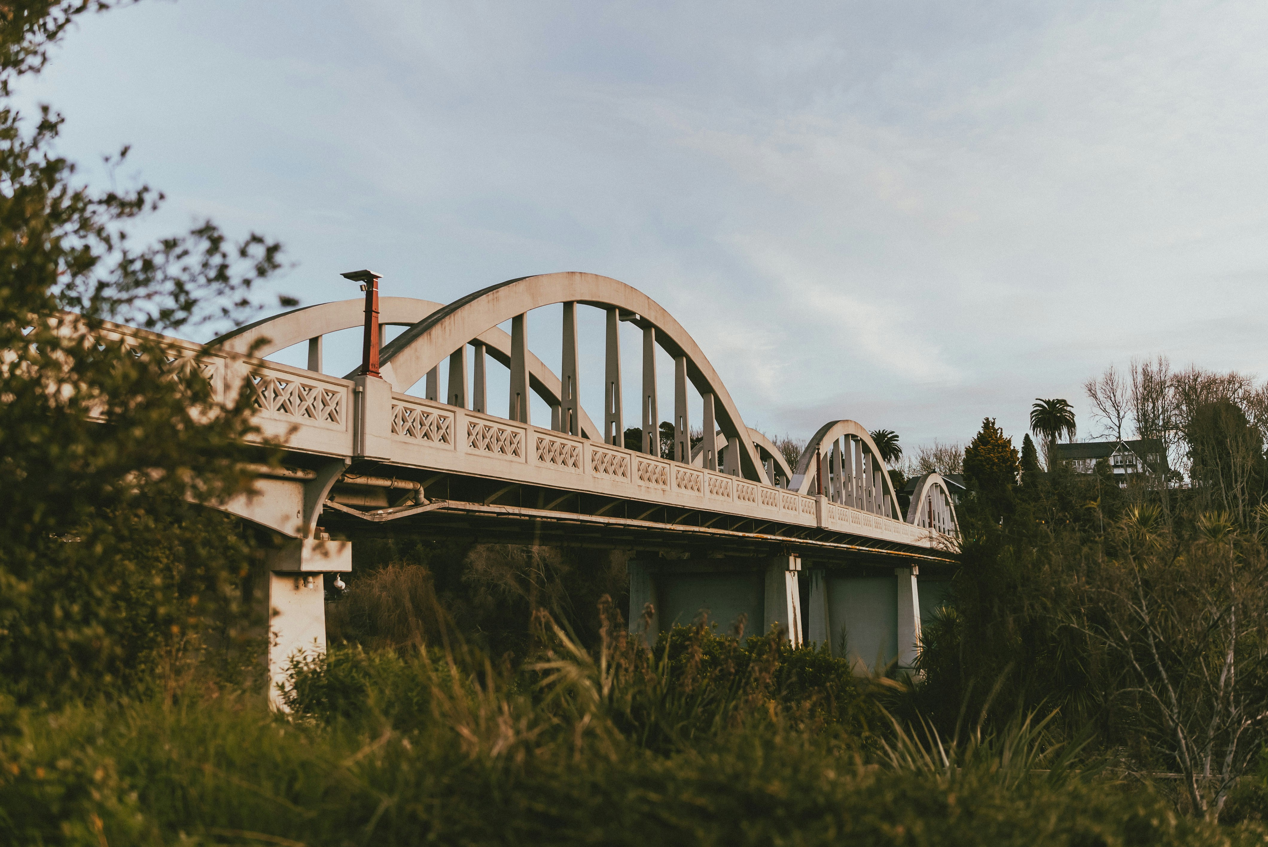 Golden-arched Bridge Framing a Quiet Hillside at Dusk